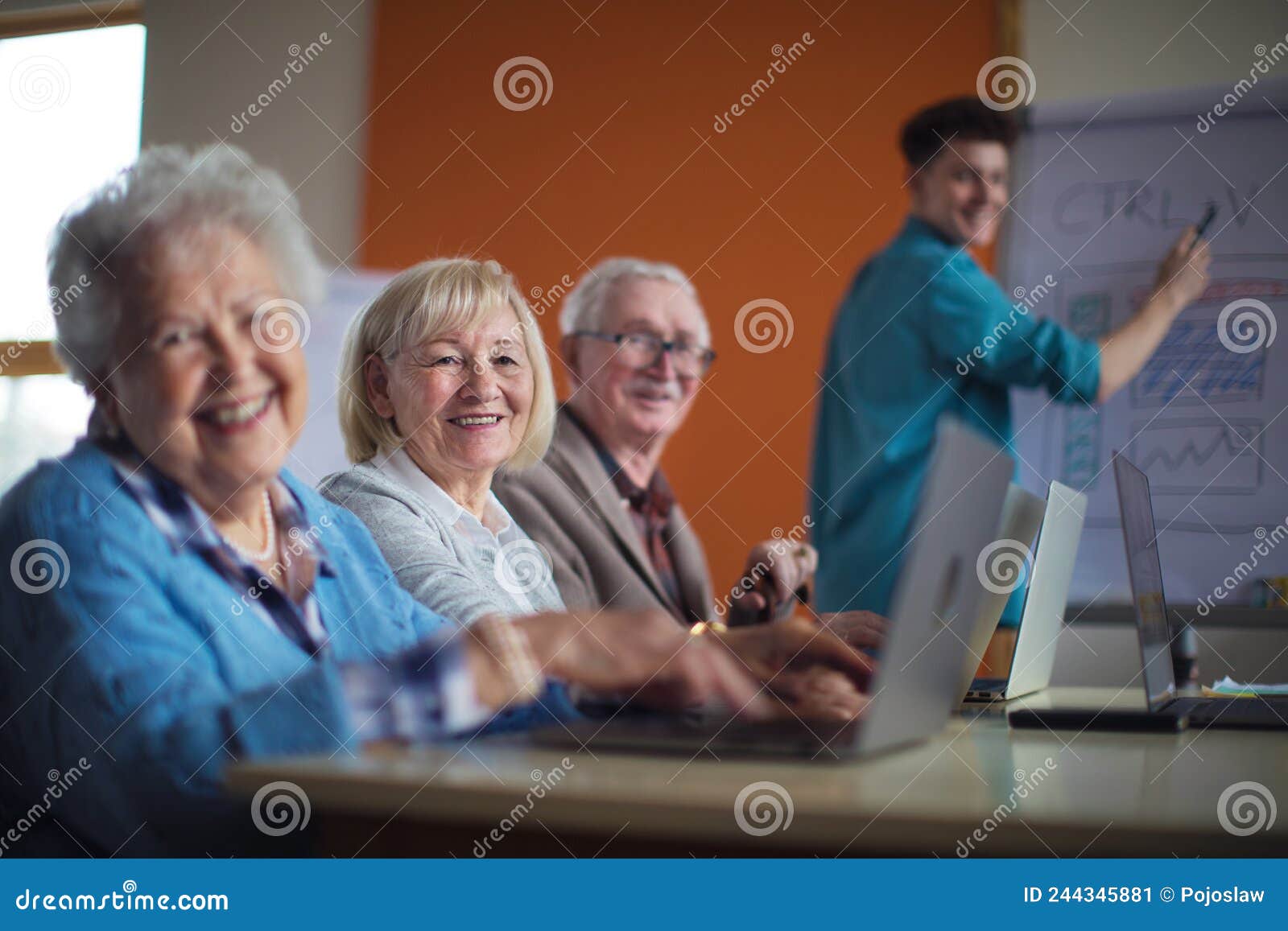 Senior Group in Retirement Home with Young Instructor Learning Together ...