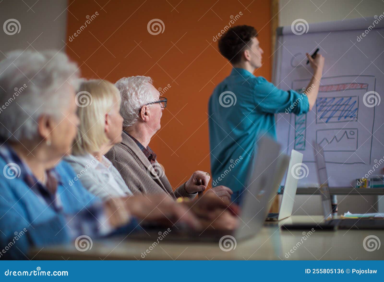 Senior Group with Young Instructor Learning Together in Computer Class ...