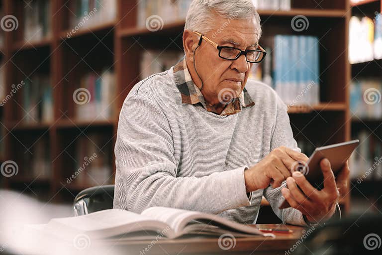 Senior Man Reading in a Library Stock Photo - Image of book, tablet ...