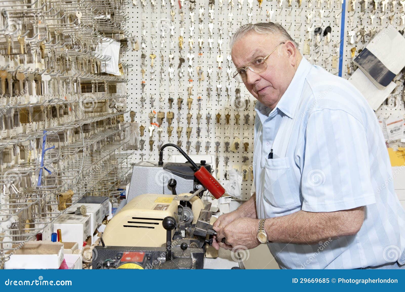 Senior Locksmith Looking Away while Making Key in Store Stock Image ...