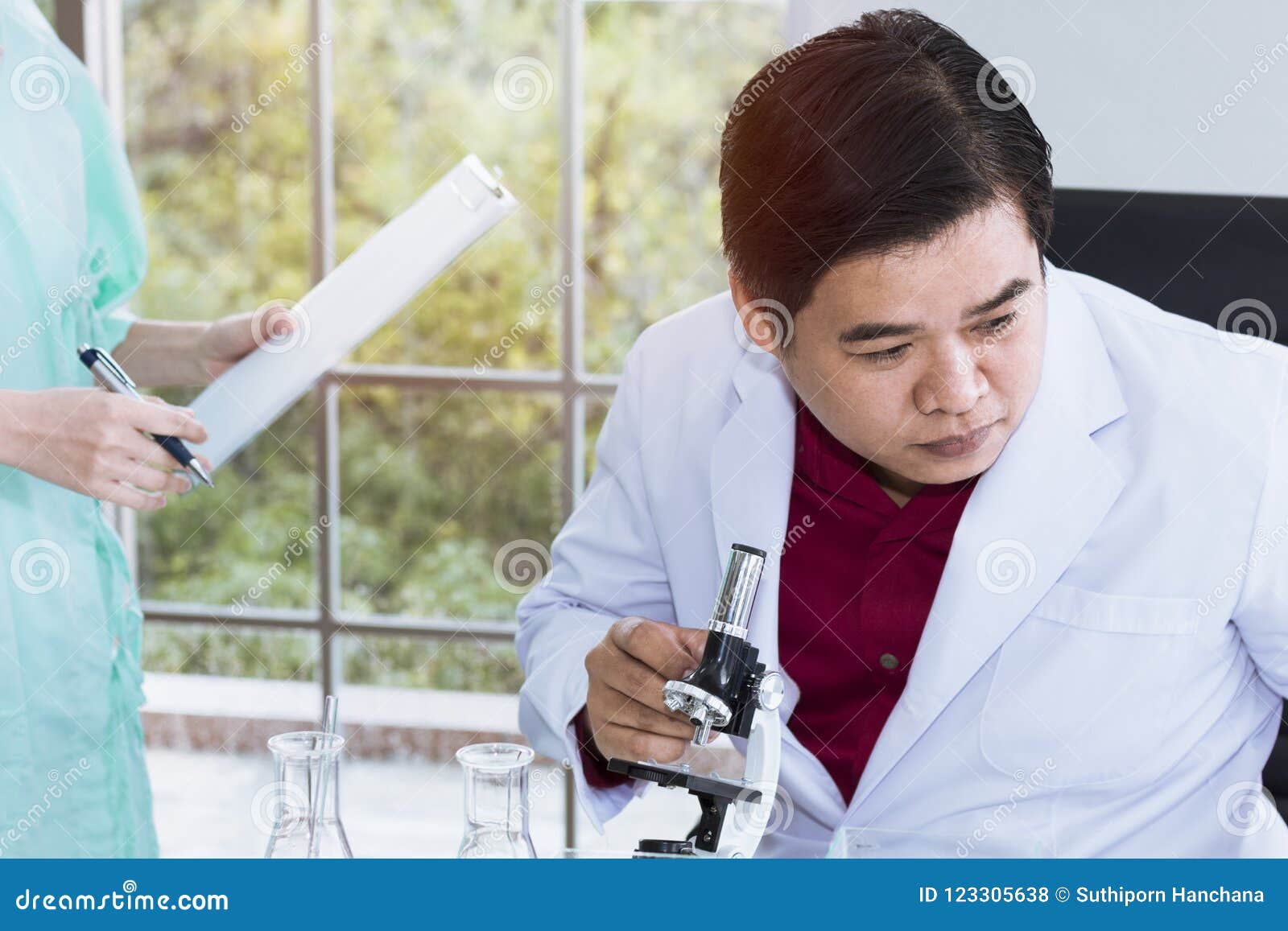 Senior Male Scientist Looking through a Microscope in a Laboratory ...