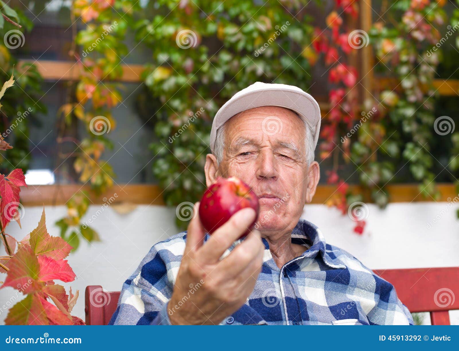 Senior man with apple stock photo. Image of courtyard - 45913292