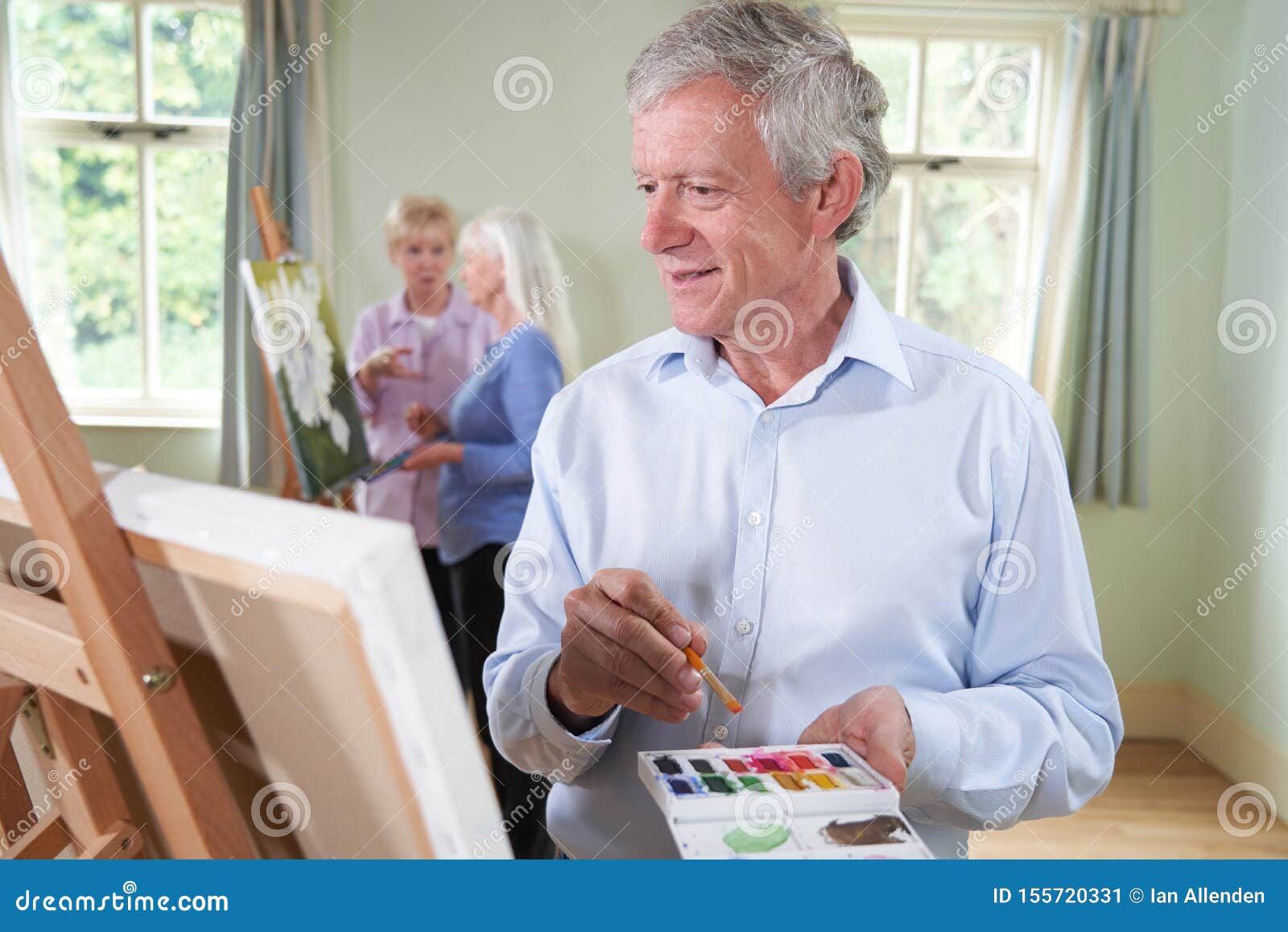 Senior Man Attending Painting Class with Teacher in Background Stock ...