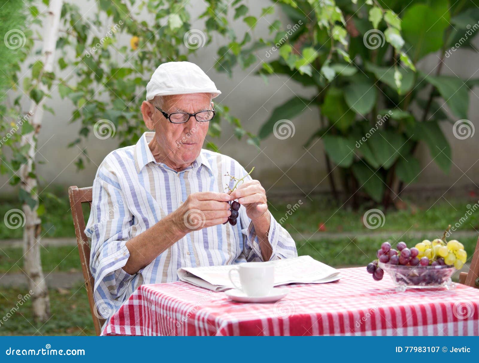 Senior man eating grape stock image. Image of lifestyle - 77983107