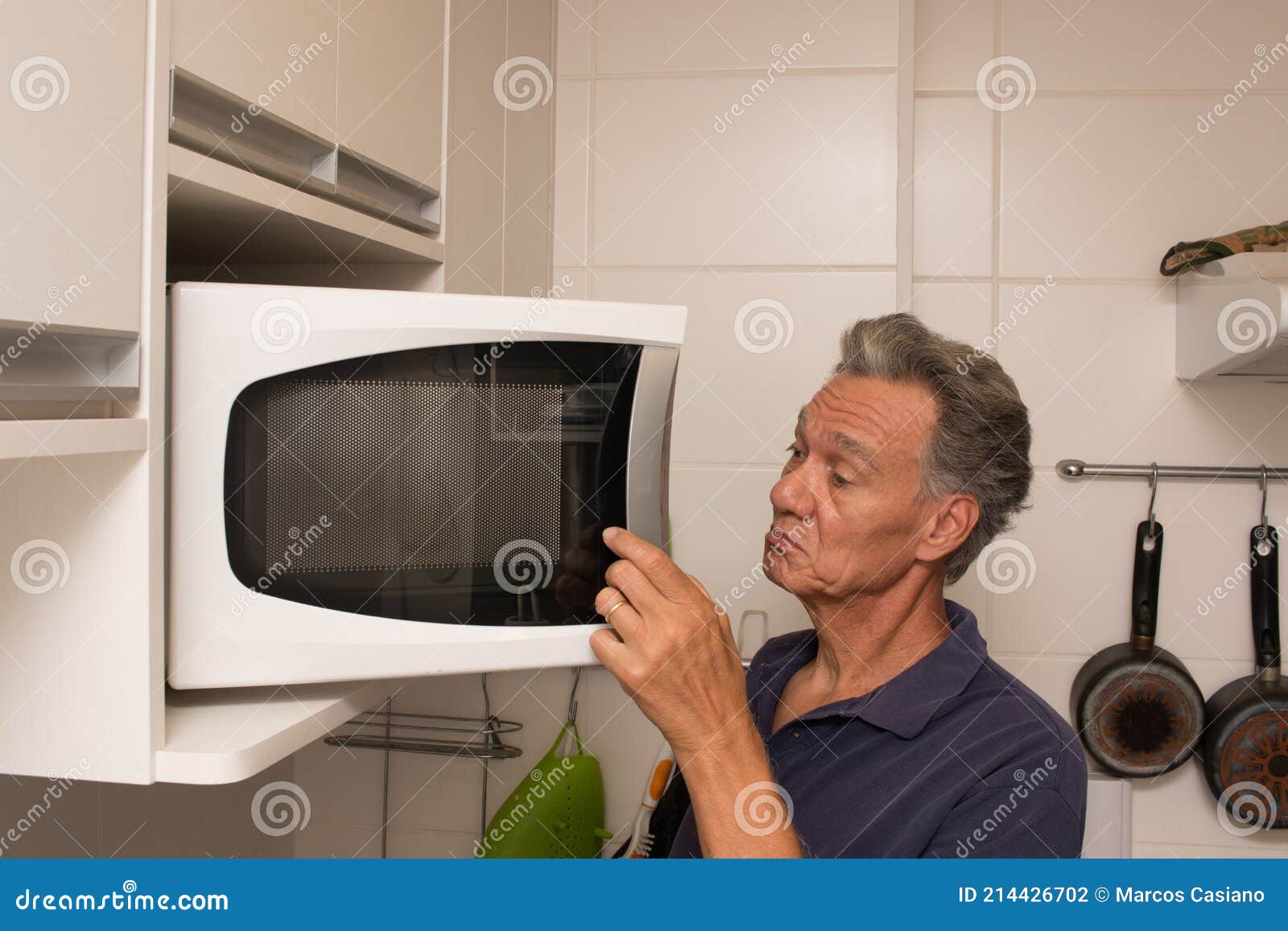 Senior Man in His Kitchen Looking into His Microwave Stock Photo ...