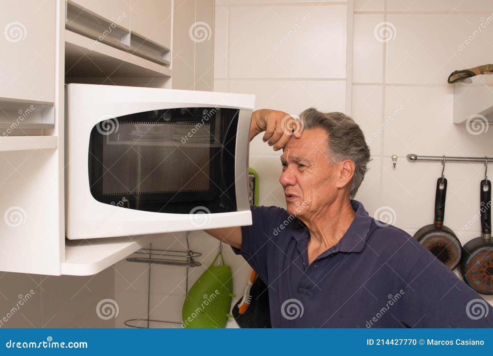 Senior Man in His Kitchen Looking into His Microwave Stock Photo ...