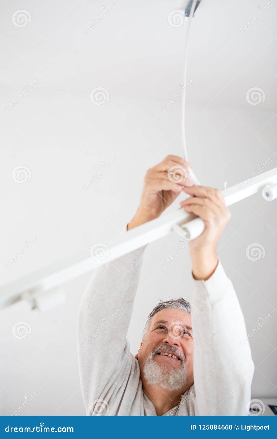Senior Man Installing a Ceiling Light in Appartment Stock Photo - Image ...