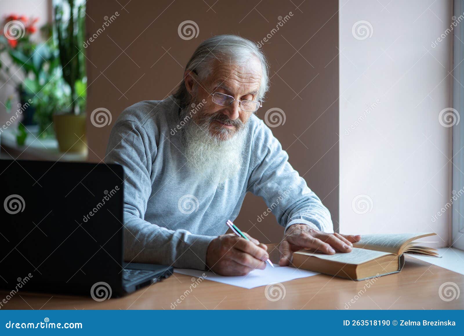 Senior Man with Laptop and Book Sitting at Table and Write Notes Stock ...