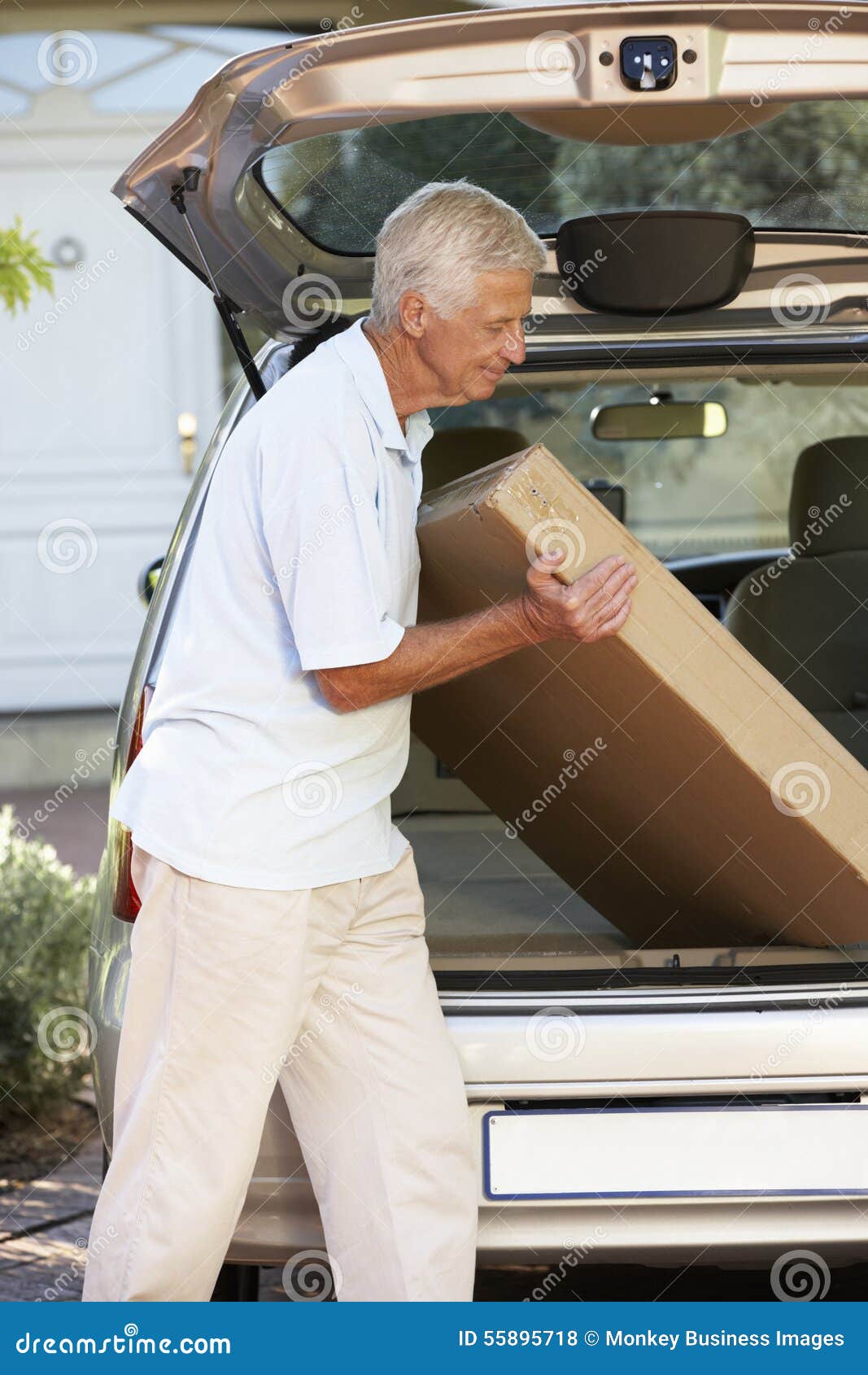 Senior Man Loading Large Package into Back of Car Stock Photo - Image ...