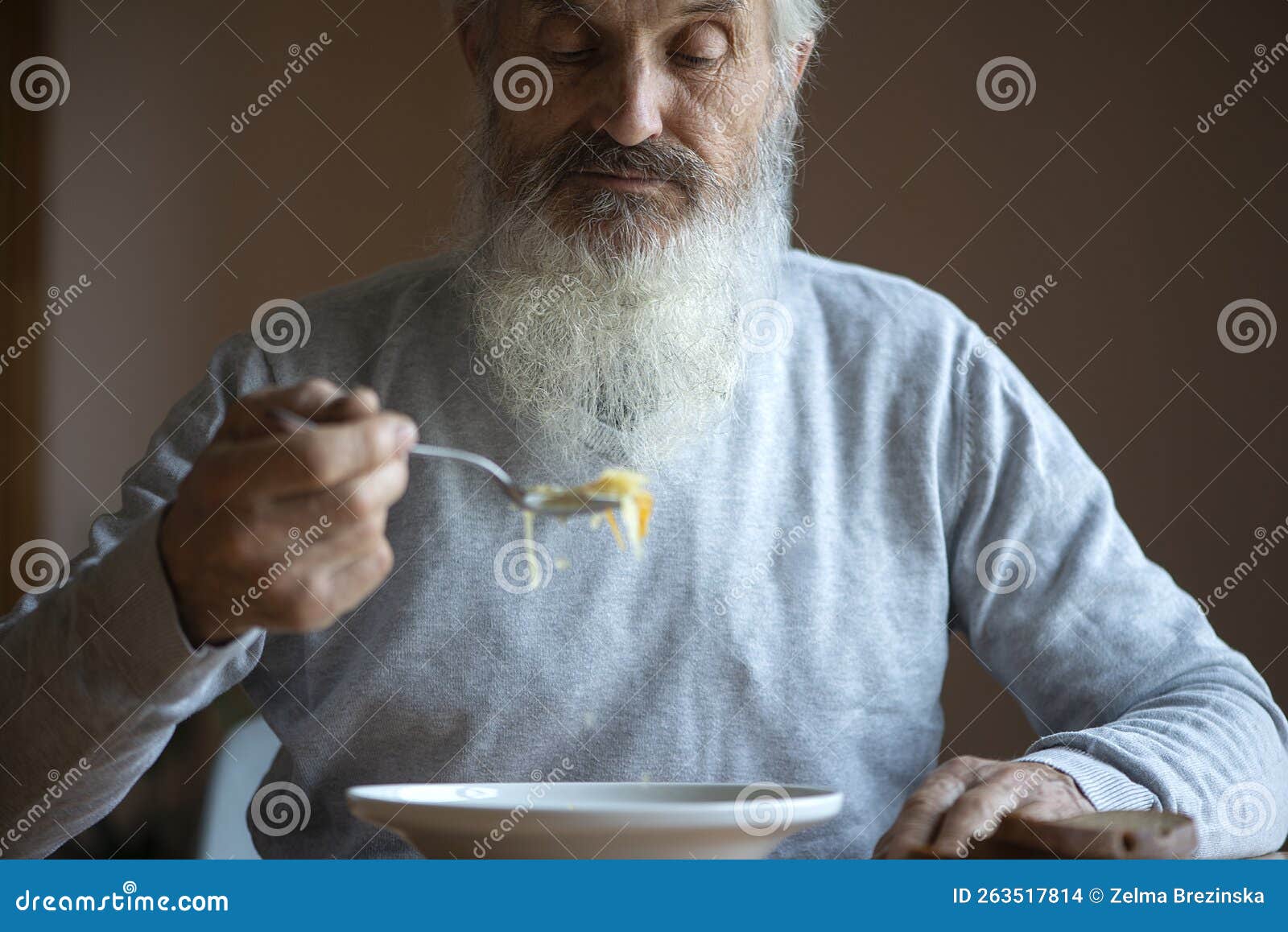 Old Sad Man with a Long Gray Beard Sitting by the Table and Eating Soup ...