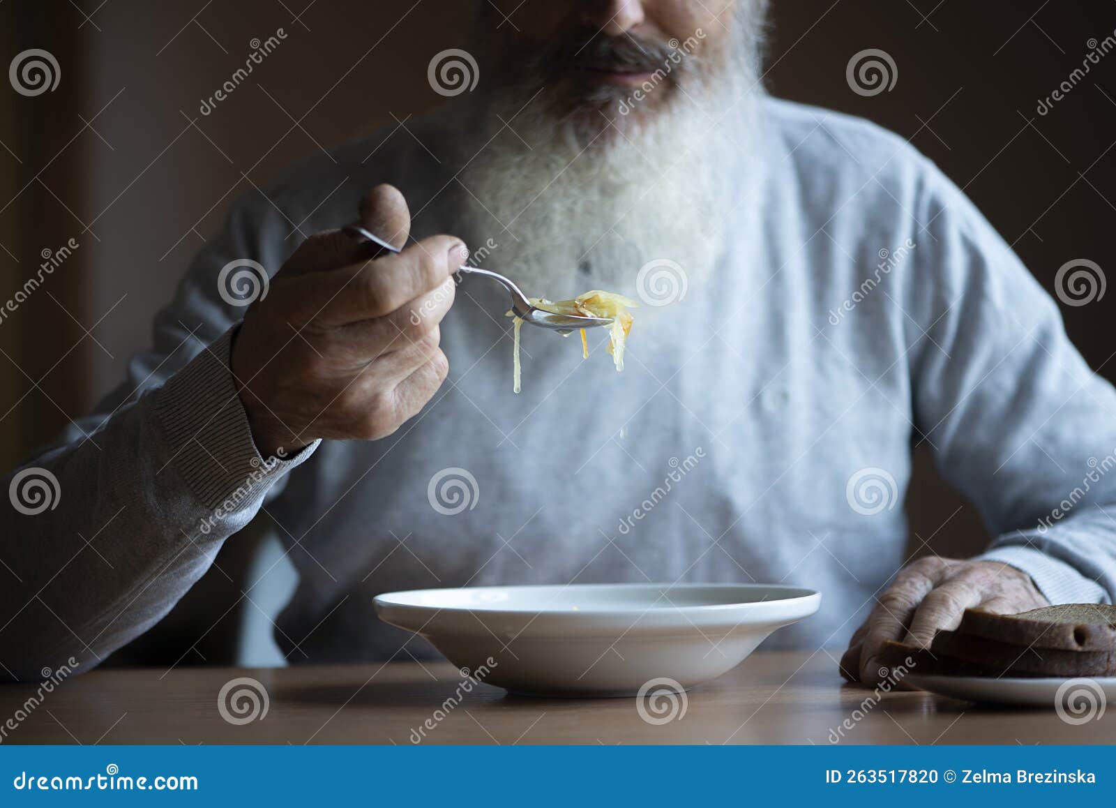 Old Sad Man with a Long Gray Beard Sitting by the Table and Eating Soup ...