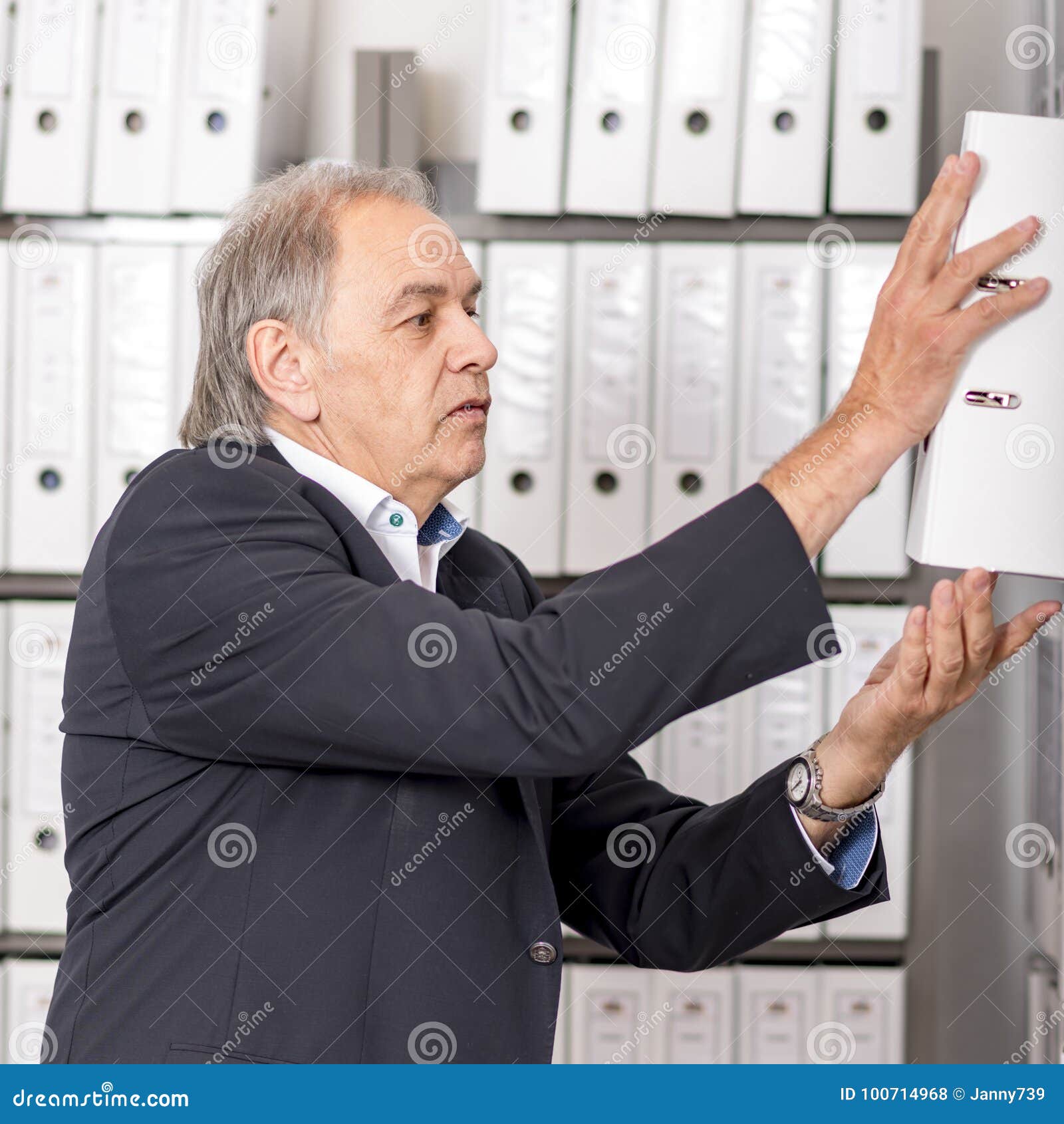 Senior Man Puts a Document into a Shelf Stock Photo - Image of gray ...