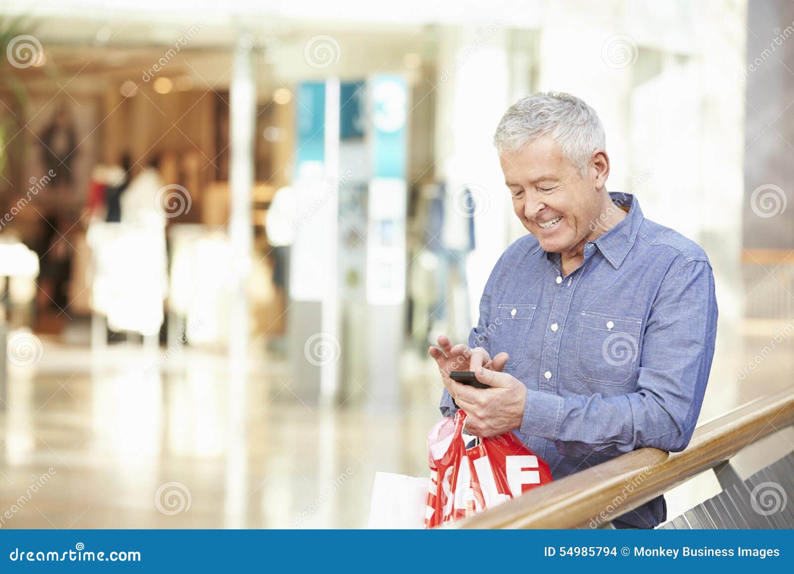 Senior Man in Shopping Mall Using Mobile Phone Stock Photo - Image of ...