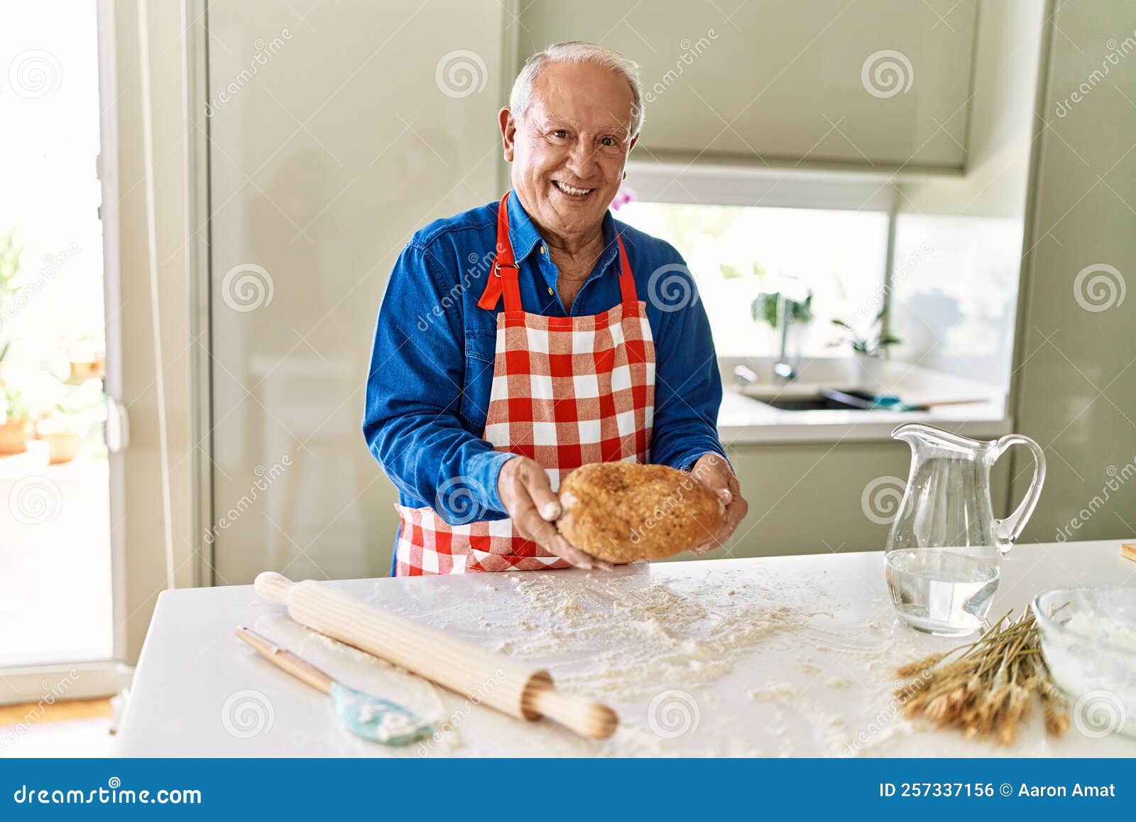 Senior Man Smiling Confident Holding Homemade Bread at Kitchen Stock ...