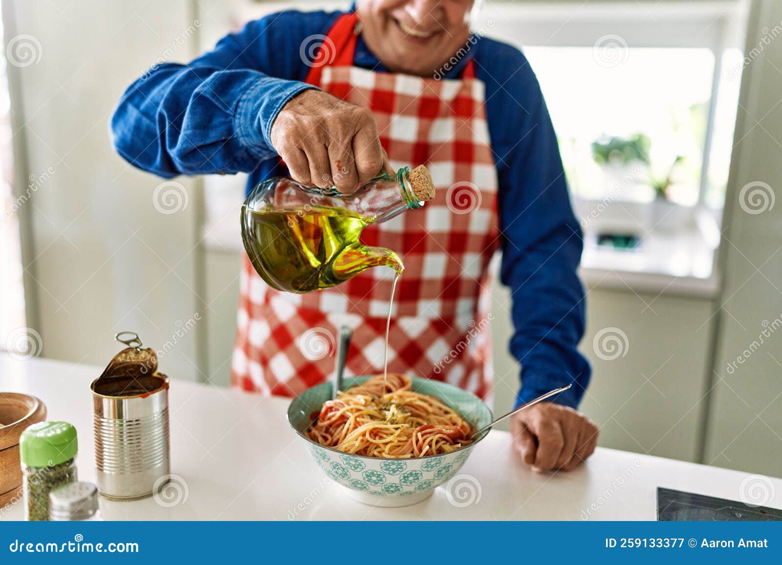 Senior Man Smiling Confident Pouring Oil on Spaghetti at Kitchen Stock ...