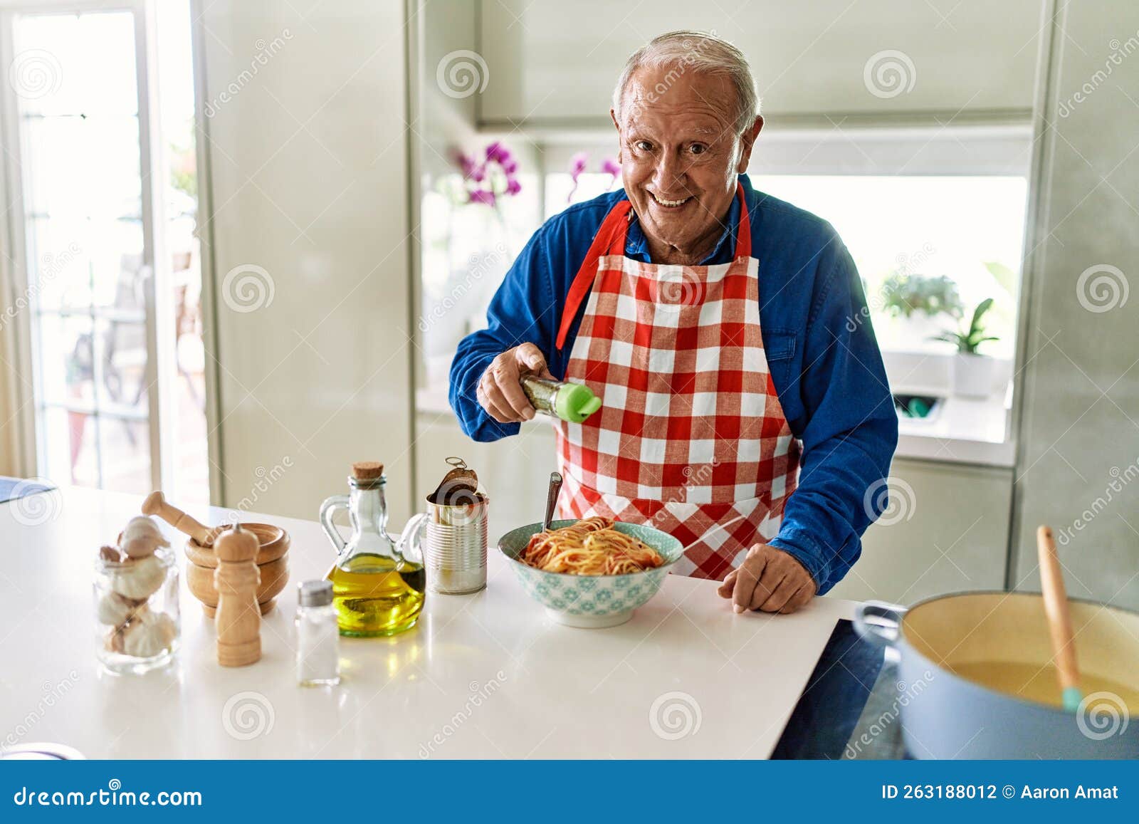 Senior Man Smiling Confident Pouring Oregano on Spaghetti at Kitchen ...