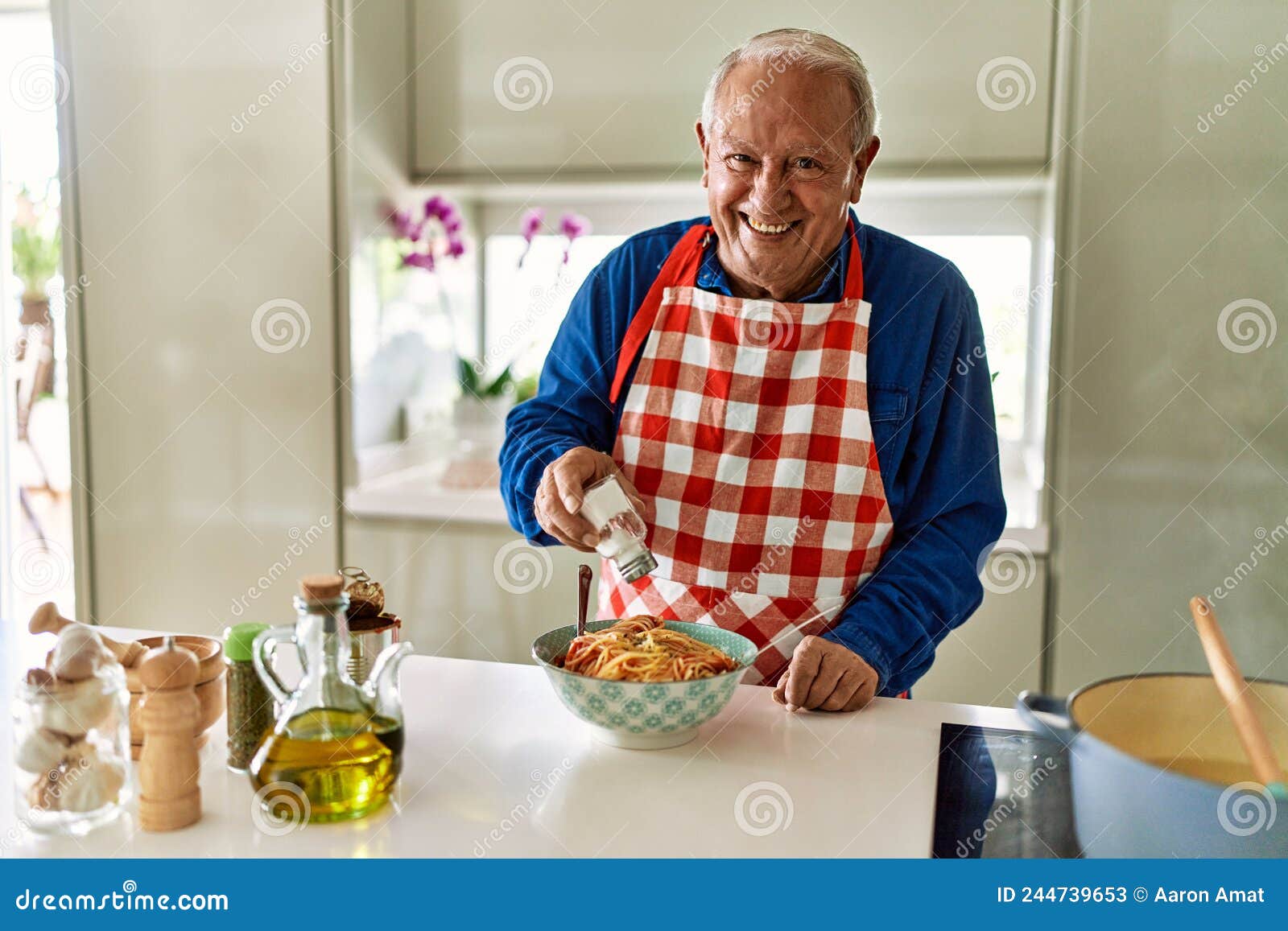 Senior Man Smiling Confident Pouring Salt on Spaghetti at Kitchen Stock ...