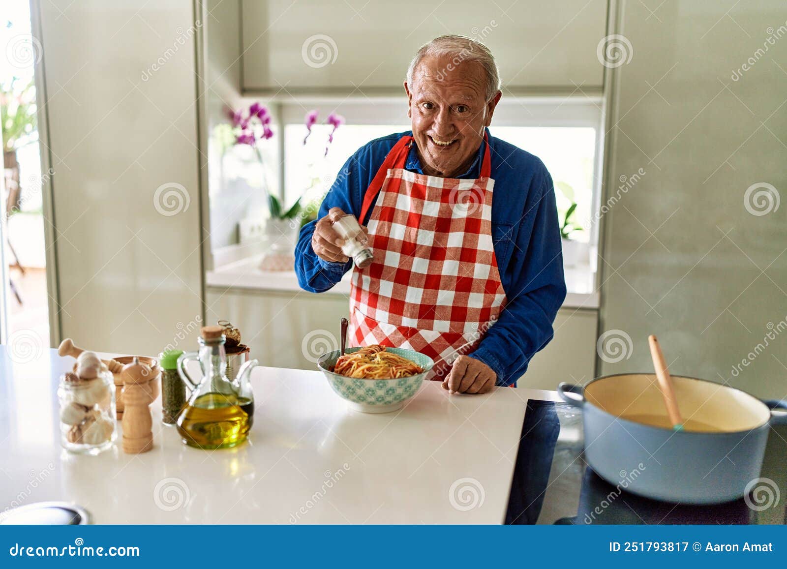 Senior Man Smiling Confident Pouring Salt on Spaghetti at Kitchen Stock ...