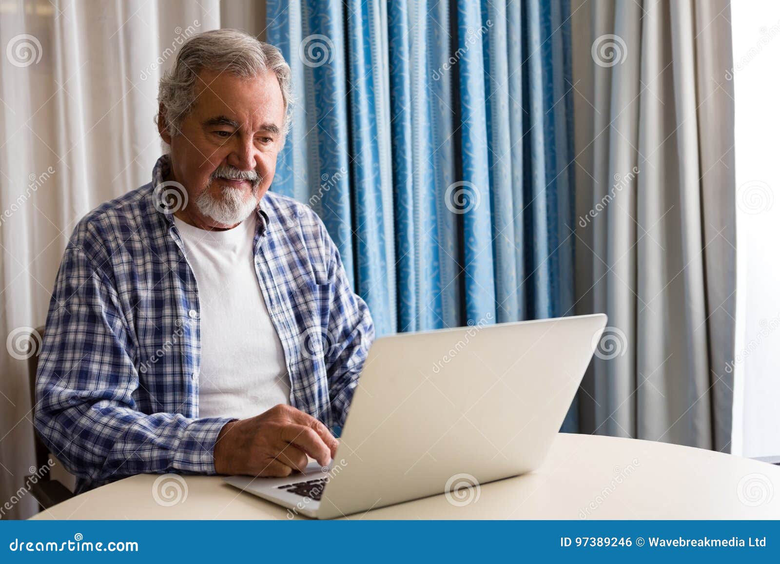 Senior Man Using Laptop while Sitting at Table Stock Photo - Image of ...