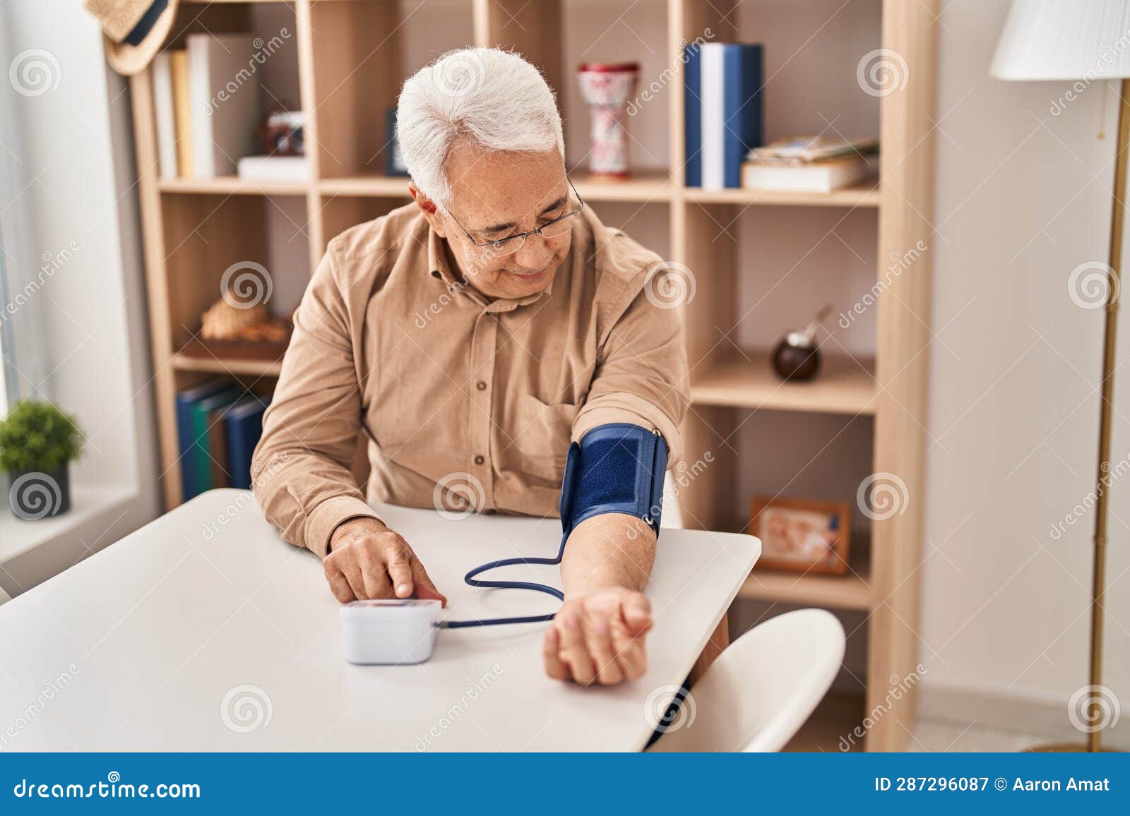 Senior Man Using Tensiometer Sitting on Table at Home Stock Image ...