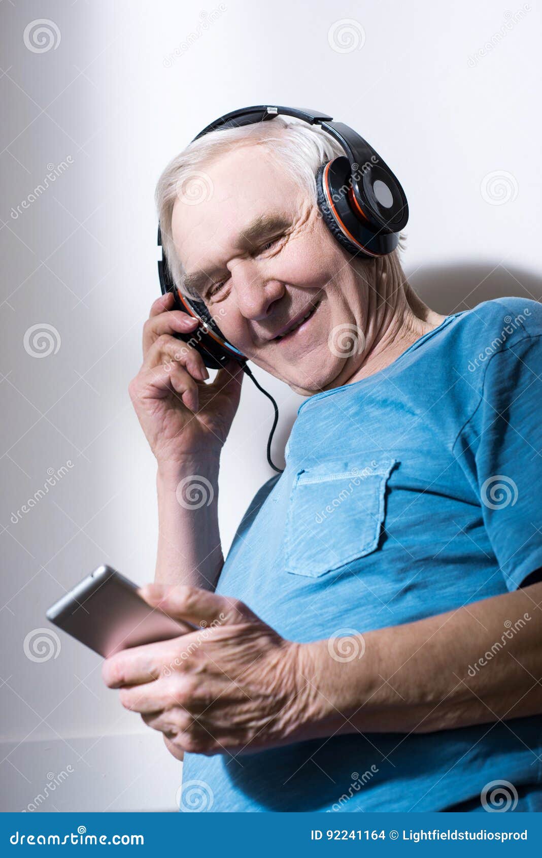 Senior Man Wearing Headphones Using Smartphone Stock Photo - Image of ...