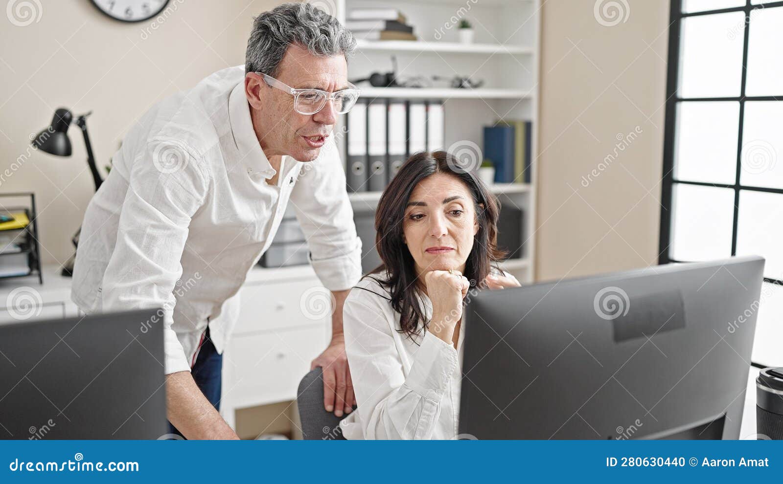 Senior Man and Woman Business Workers Using Computer Speaking at Office ...