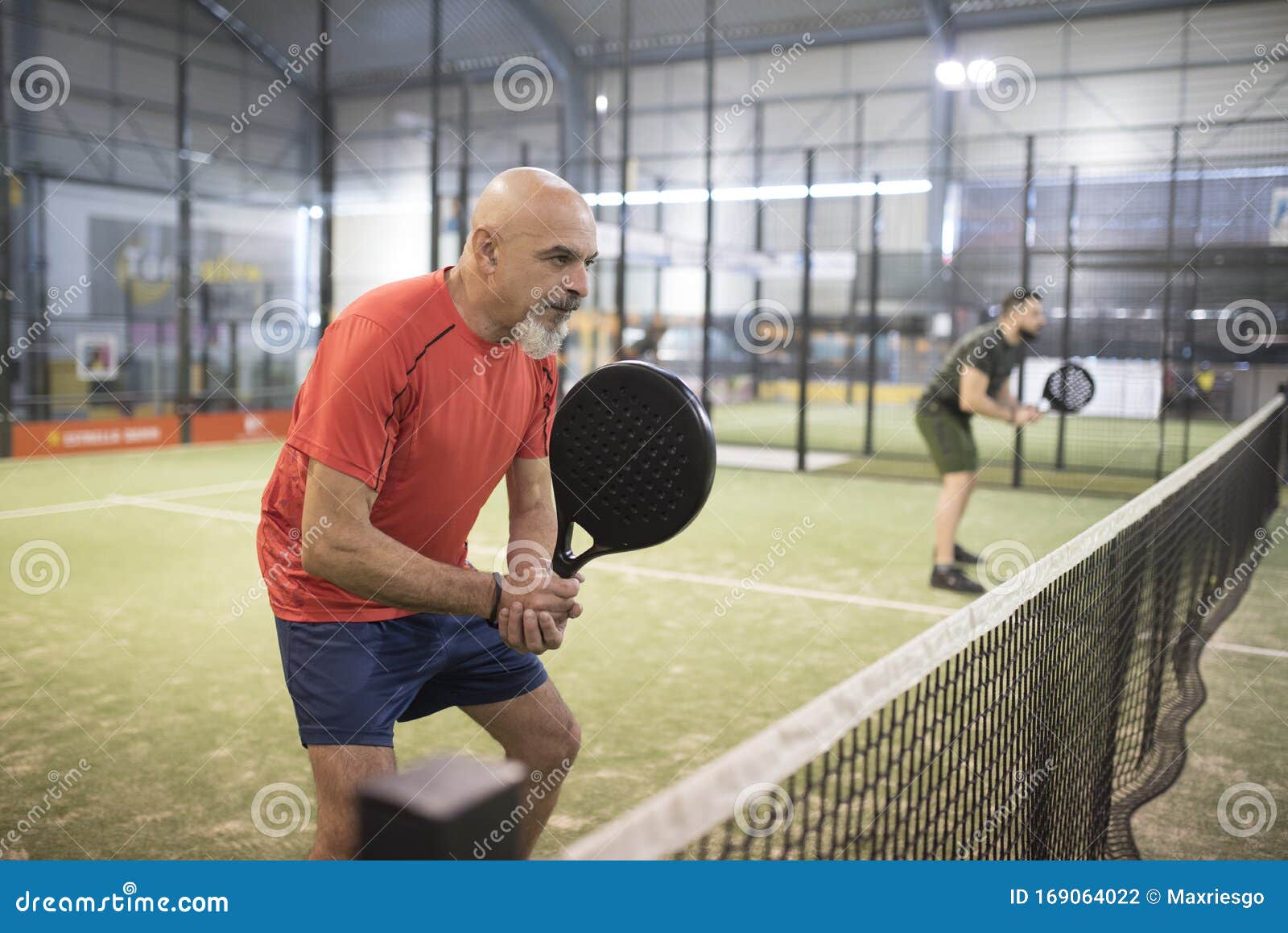 Senior Mann Und Ihr Sohn Spielen Paddle Tennis Auf Dem Platz, Dienen ... Senior Mann Und Ihr Sohn Spielen Paddle Tennis Auf Dem Platz, Dienen ...