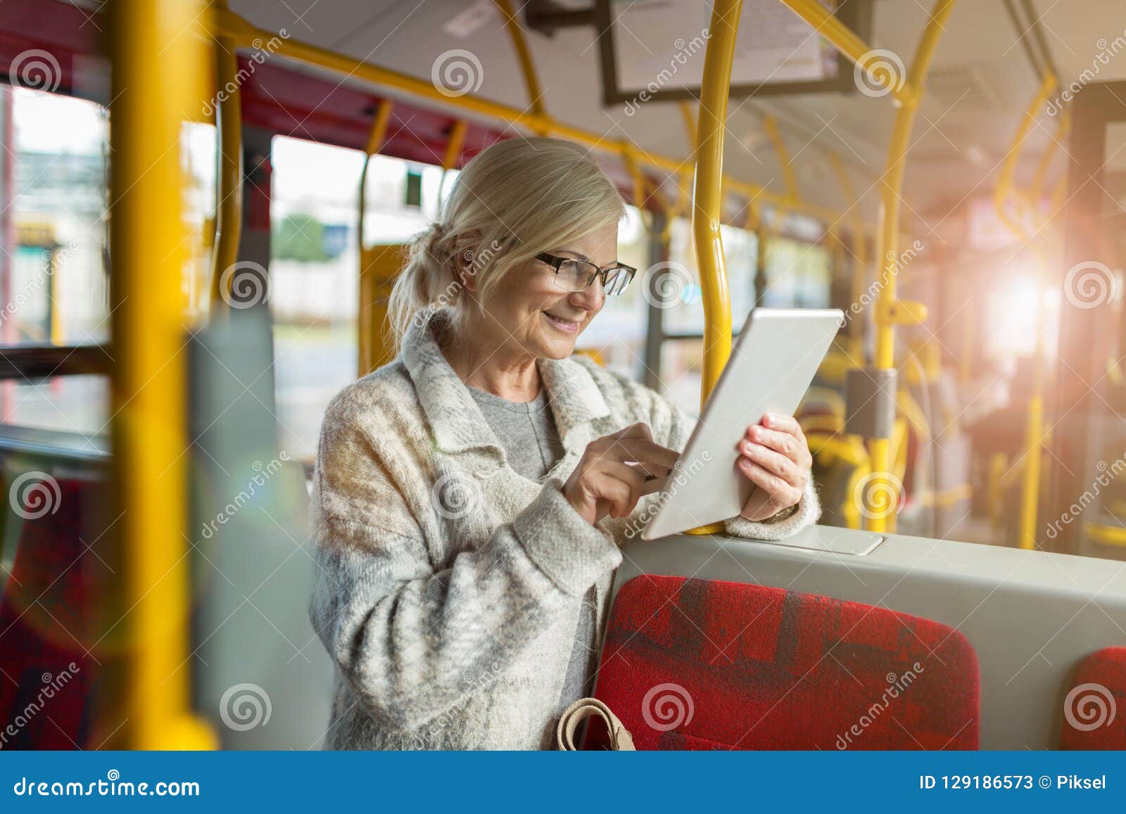 Senior Woman Using Tablet, while Riding Public Bus Stock Image - Image ...