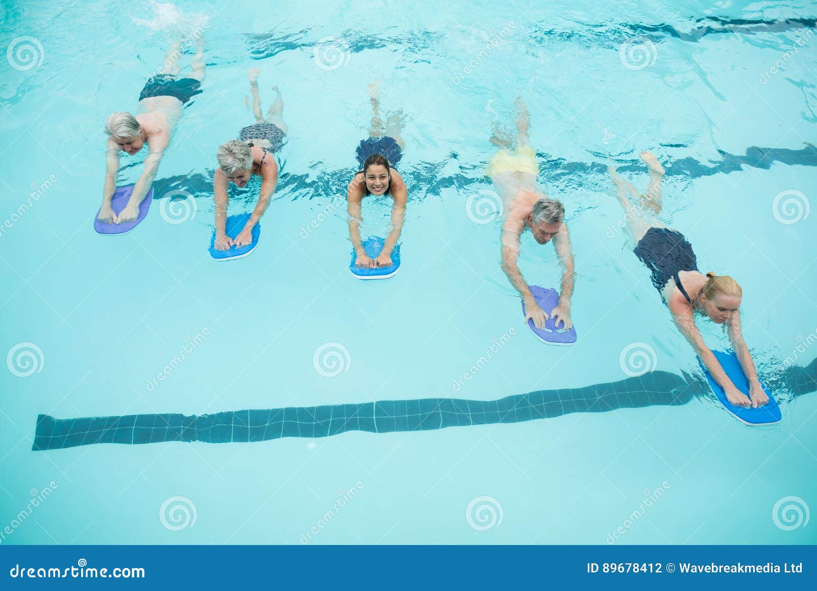 Senior Swimmers and Trainer Swimming with Kickboards in Pool Stock ...