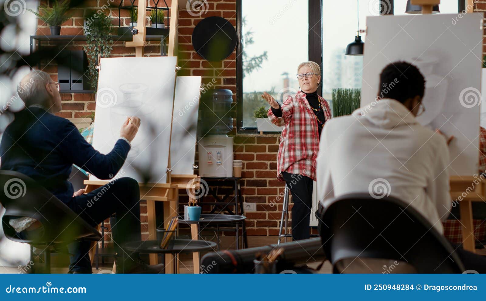 Senior Teacher Giving Art Lessons To Diverse Group of Students Stock ...