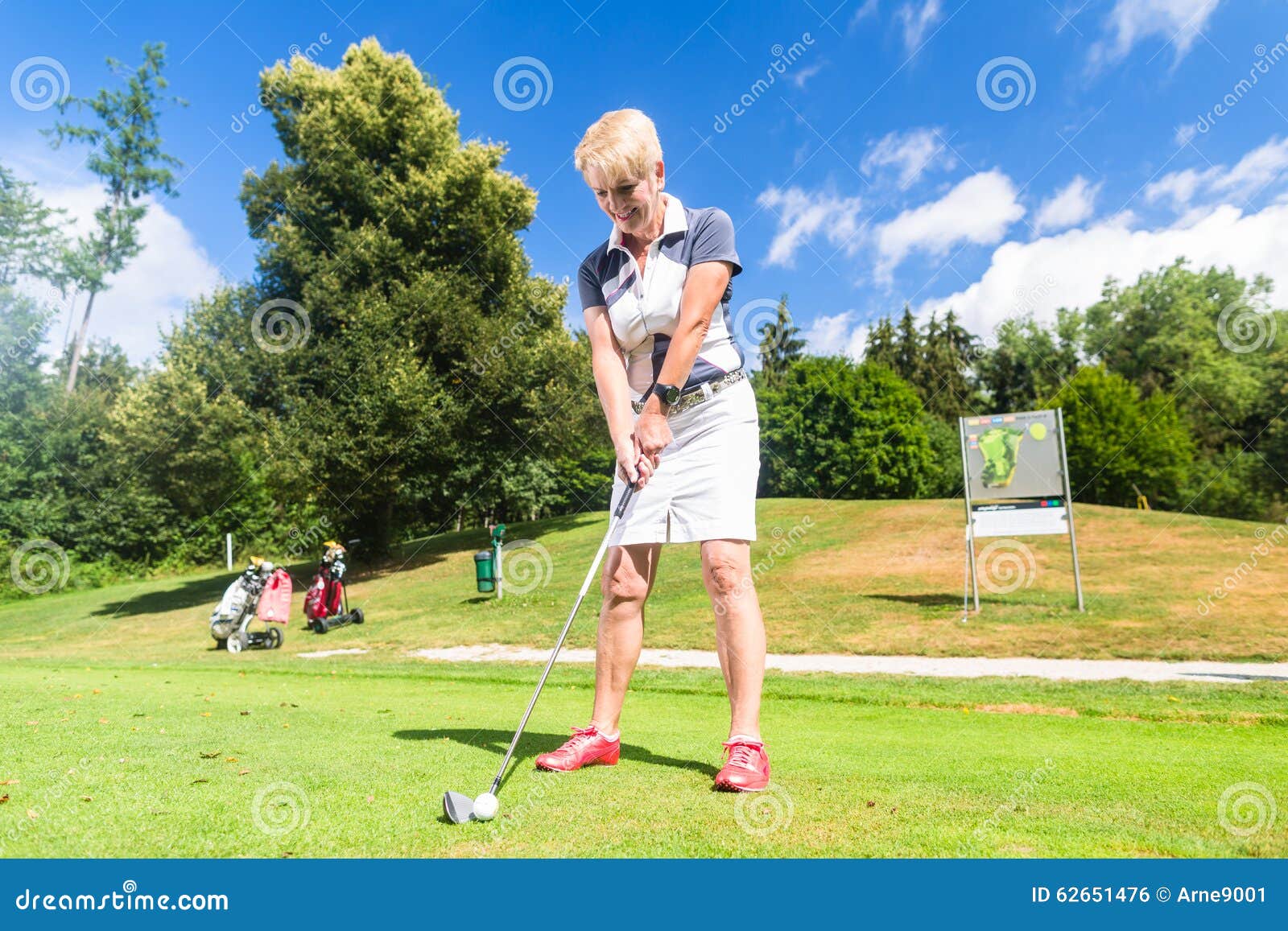 Senior Woman Doing Tee Stroke on Golf Course Stock Photo - Image of ...