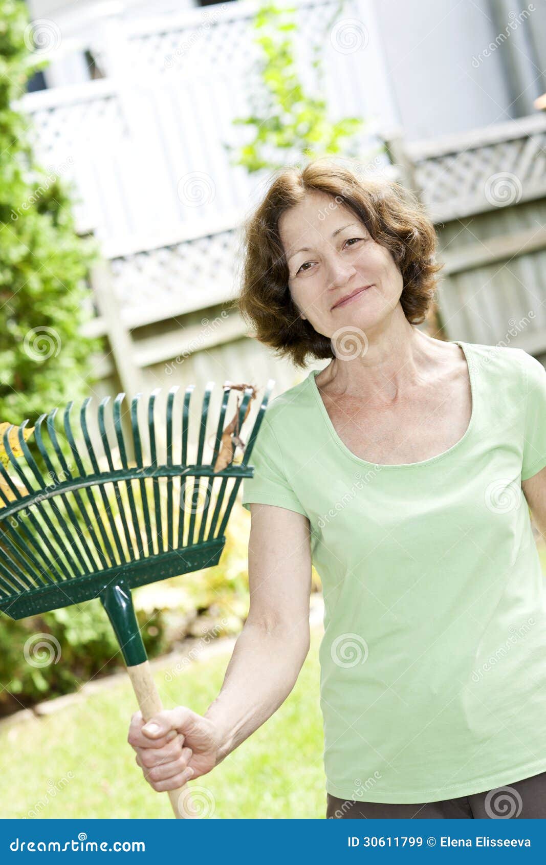 Senior woman holding rake stock image. Image of leisure - 30611799