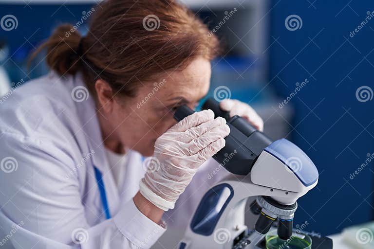 Senior Woman Scientist Using Microscope at Laboratory Stock Photo ...