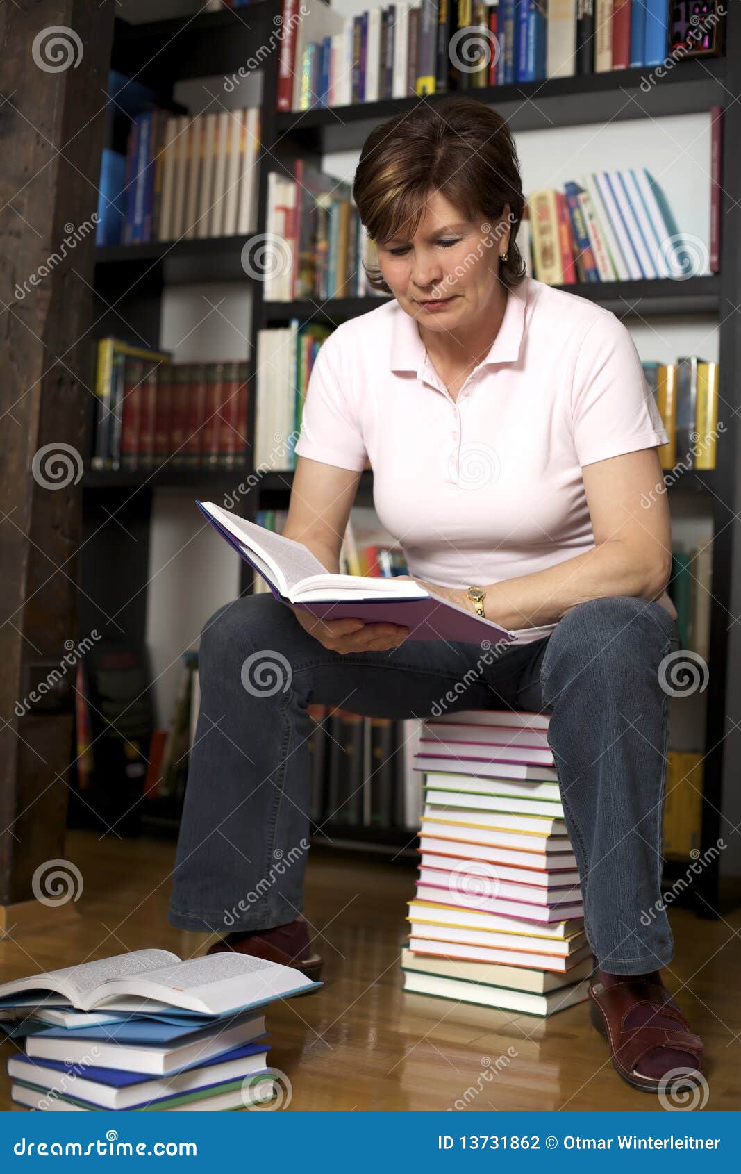 Senior Woman Sitting on Book Stack Stock Photo - Image of bookshelf ...