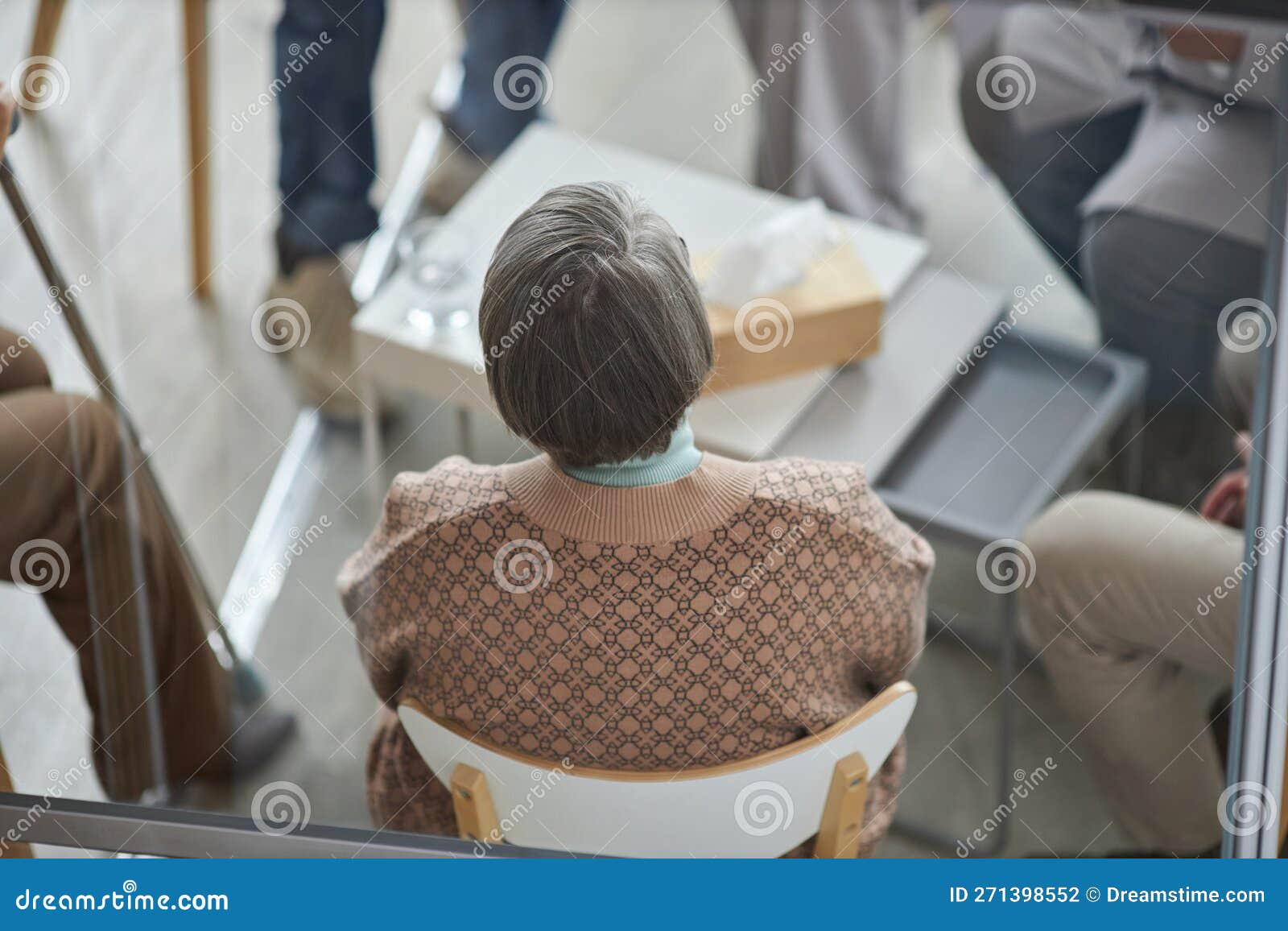 Senior Woman Sitting In Circle During Mental Health Support Group