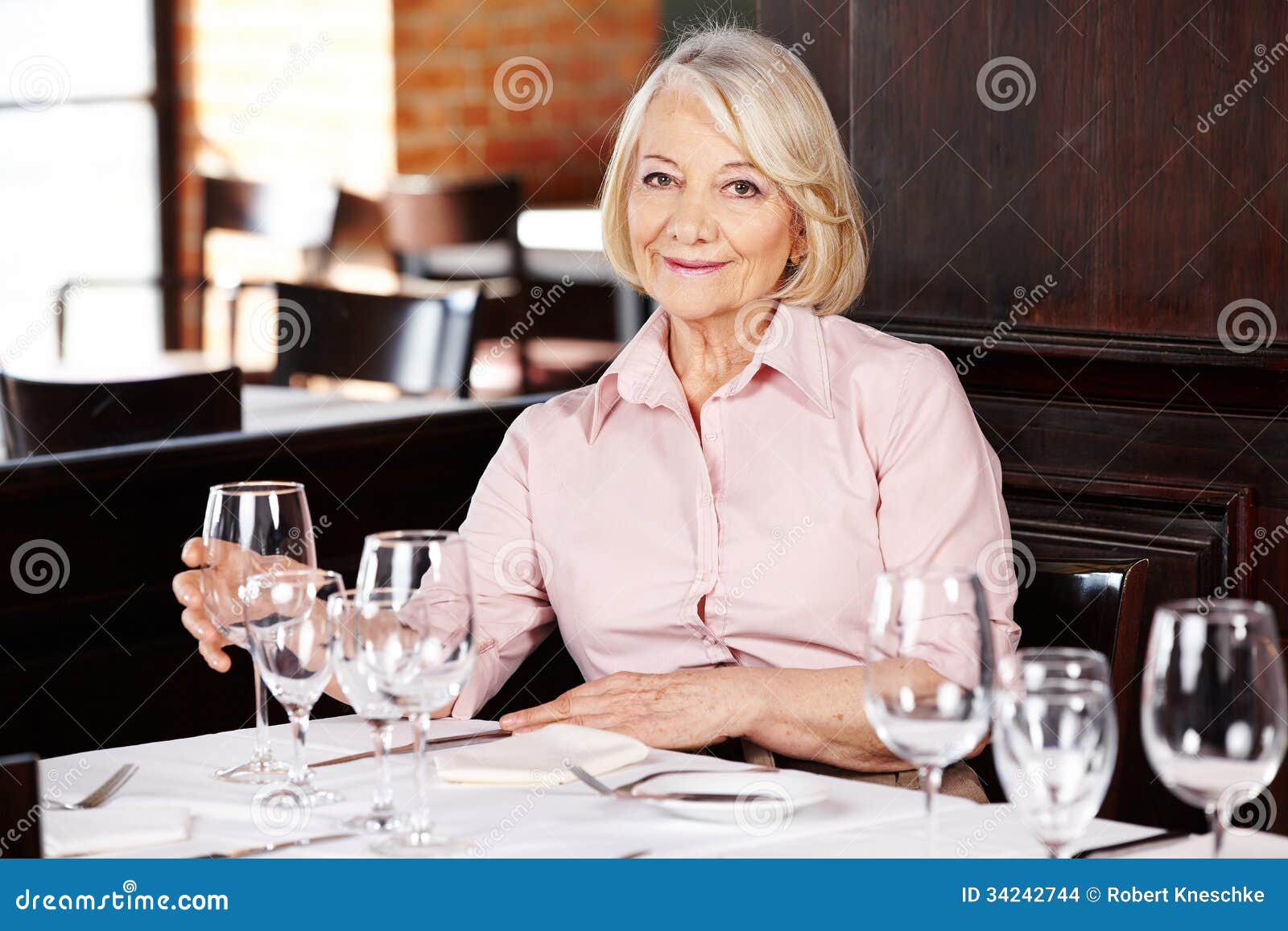 Senior Woman Sitting at Table Stock Photo - Image of smile, retiree ...