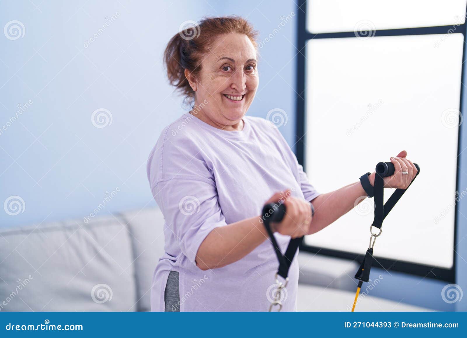 Senior Woman Smiling Confident Using Elastic Band Training at Home ...