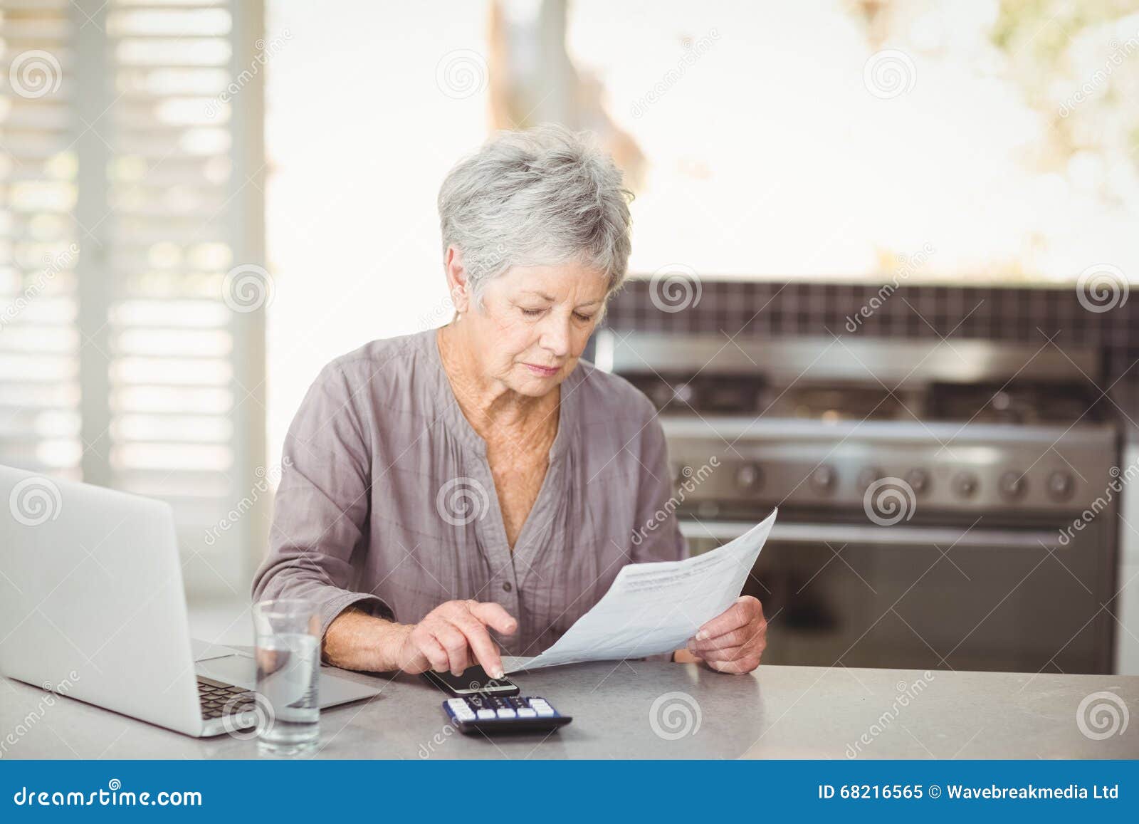 Senior Woman Using Calculator while Holding Document Stock Image ...