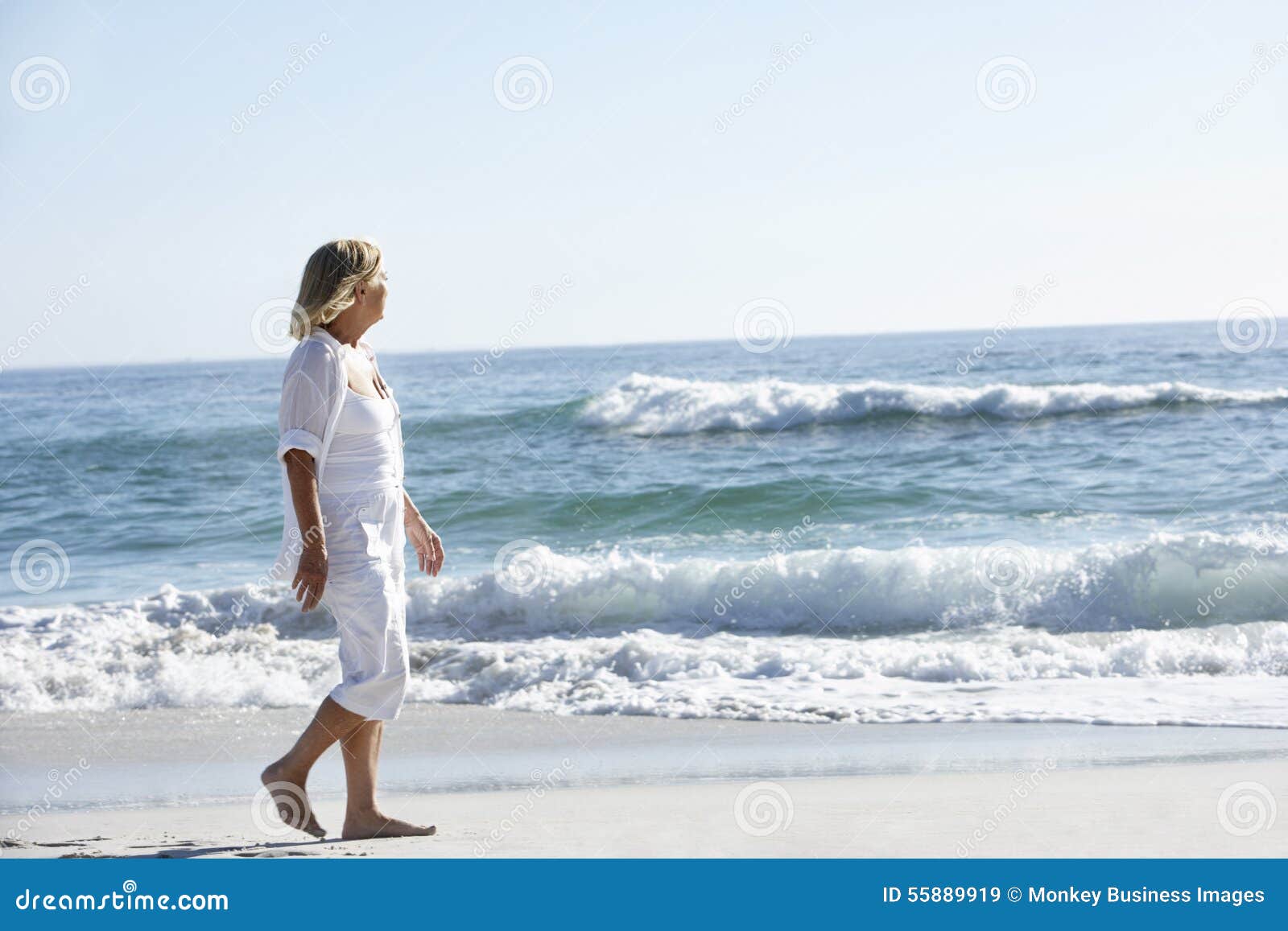 Senior Woman Walking Along Sandy Beach Stock Image - Image of mature ...