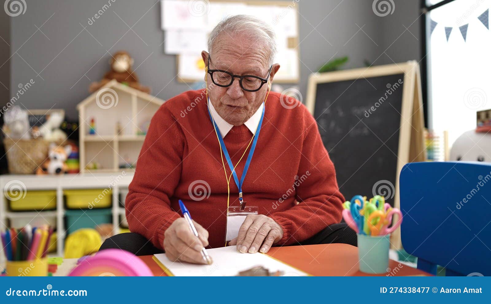 Senior Working As Teacher Writing on Papers and Talking at Kindergarten ...
