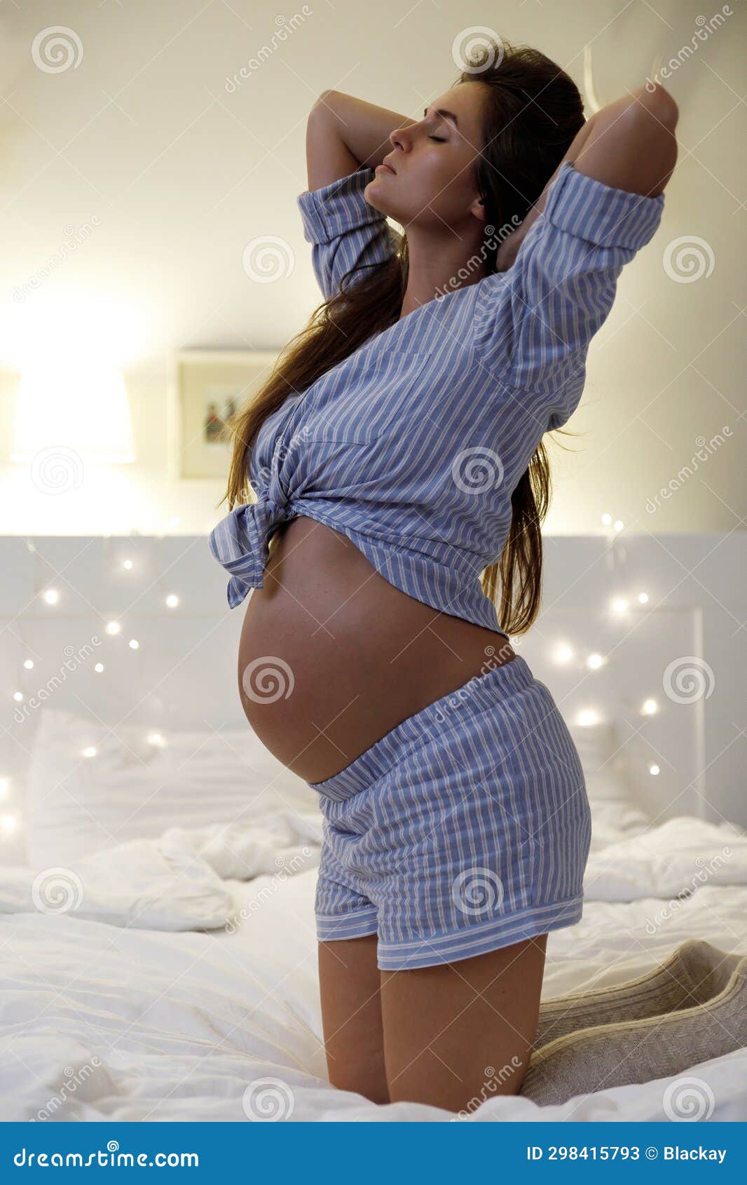 Sensual Pregnant Woman On The Bed In Her Cozy Apartment Stock Image