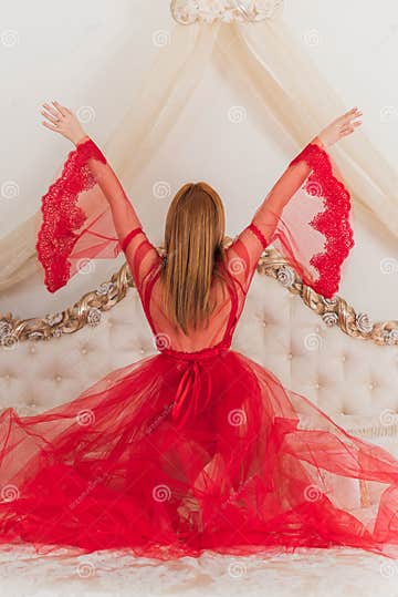 Sensual Red Hair Woman In A Red Lace Boudoir Dress On A Bed Stock Image