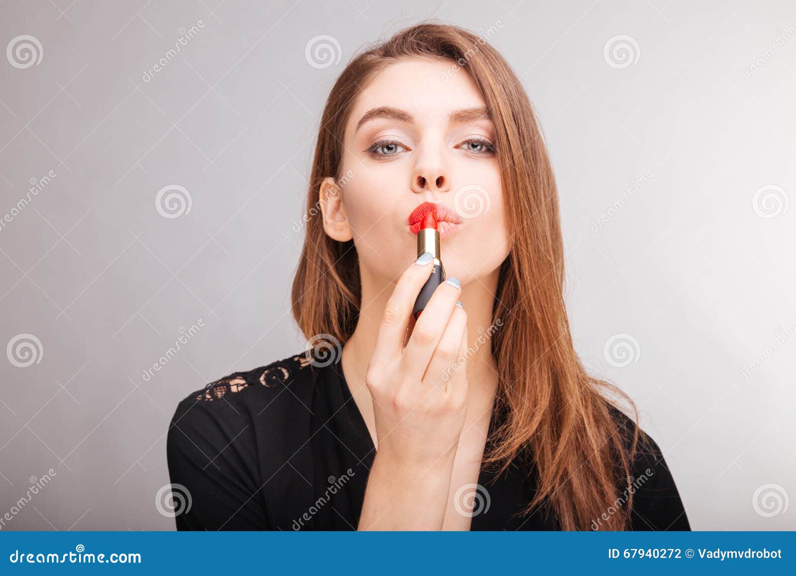 Sensual Woman Using And Demonstrating Red Lipstick On Her Lips Stock