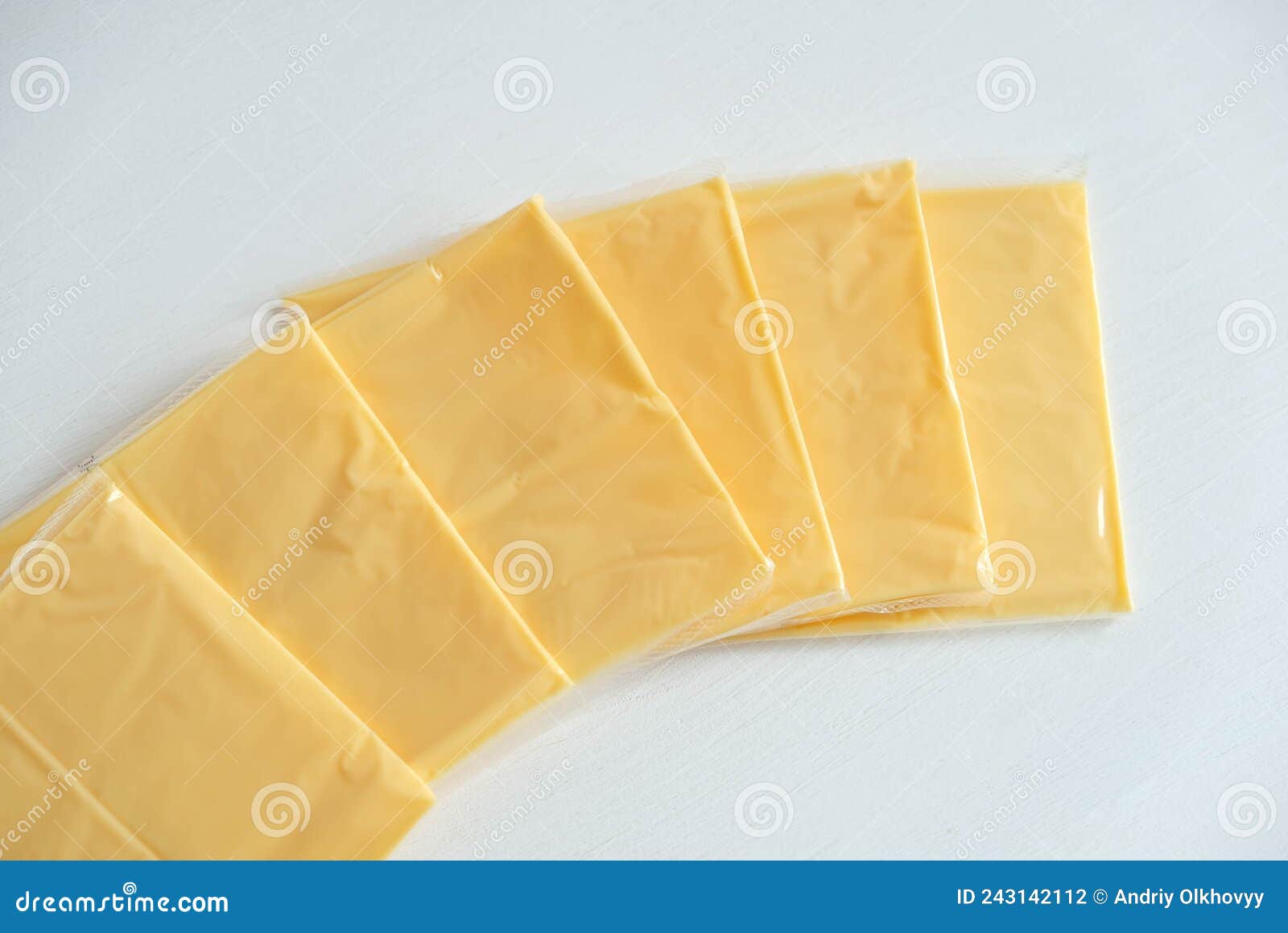 Separately Packed Cheese Slices on a White Wooden Table Background ...