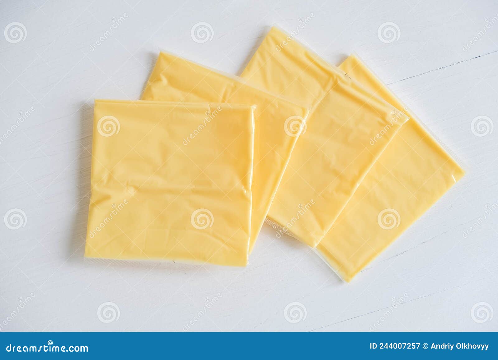 Separately Packed Cheese Slices on a White Wooden Table Background ...
