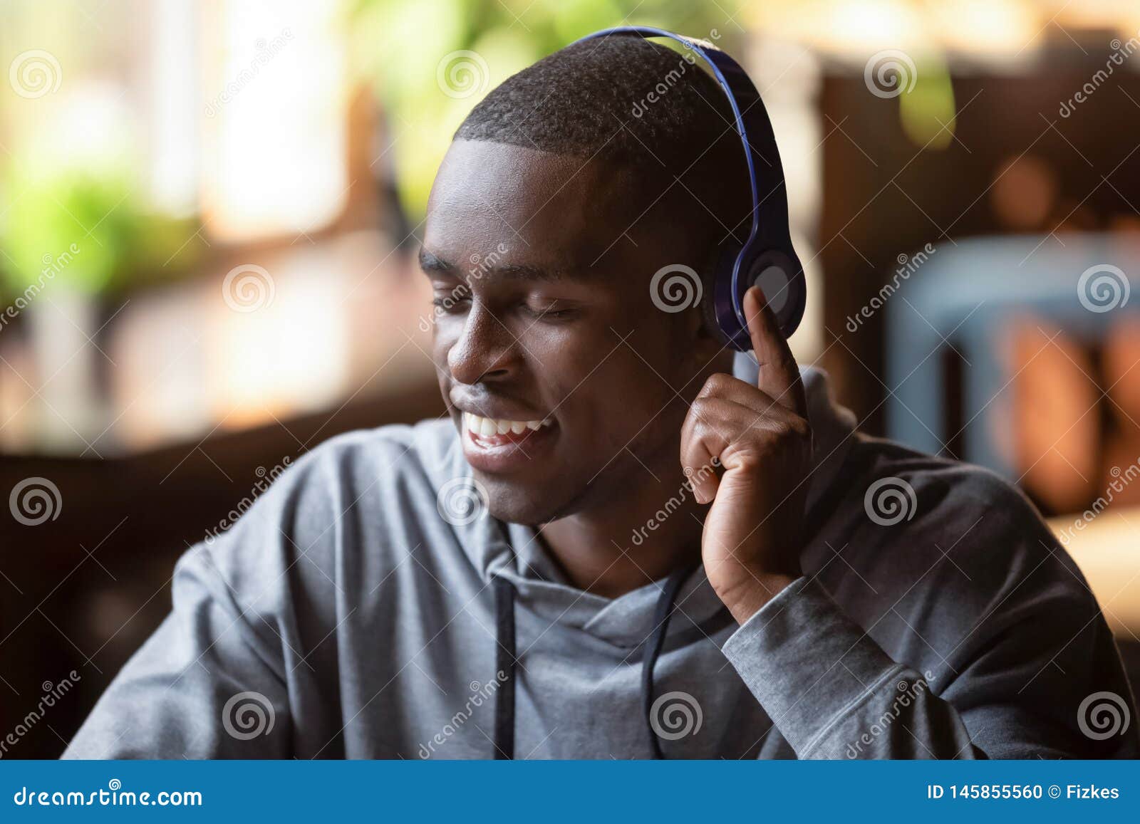 Serene African American Guy Wearing Headphones Listening Favorite Music