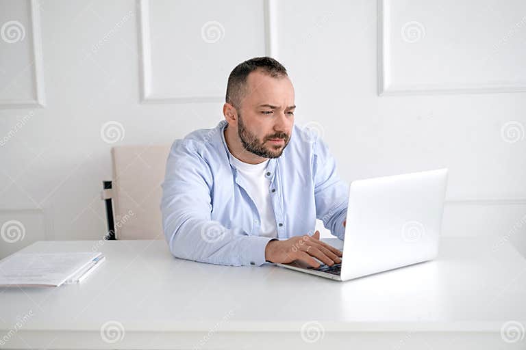 A Serious Bearded Male Programmer at Laptop is Seriously Looking at the ...