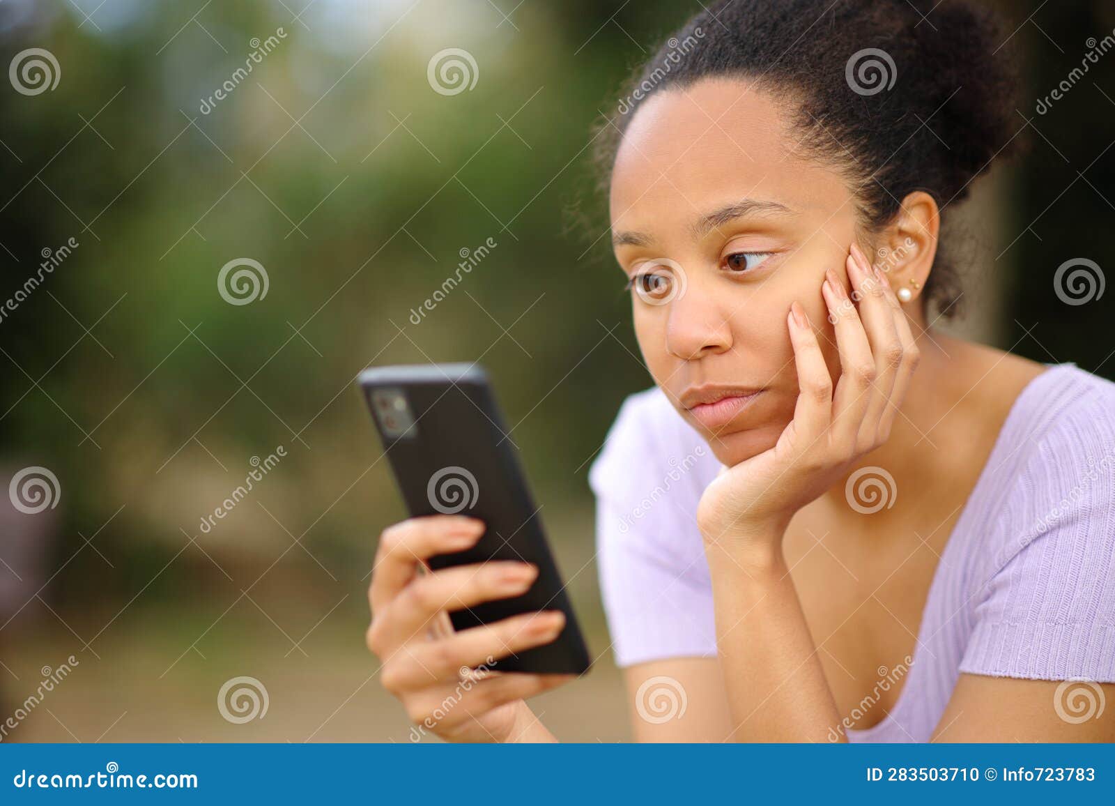 Serious Black Woman Using Cell Phone in a Park Stock Photo - Image of ...