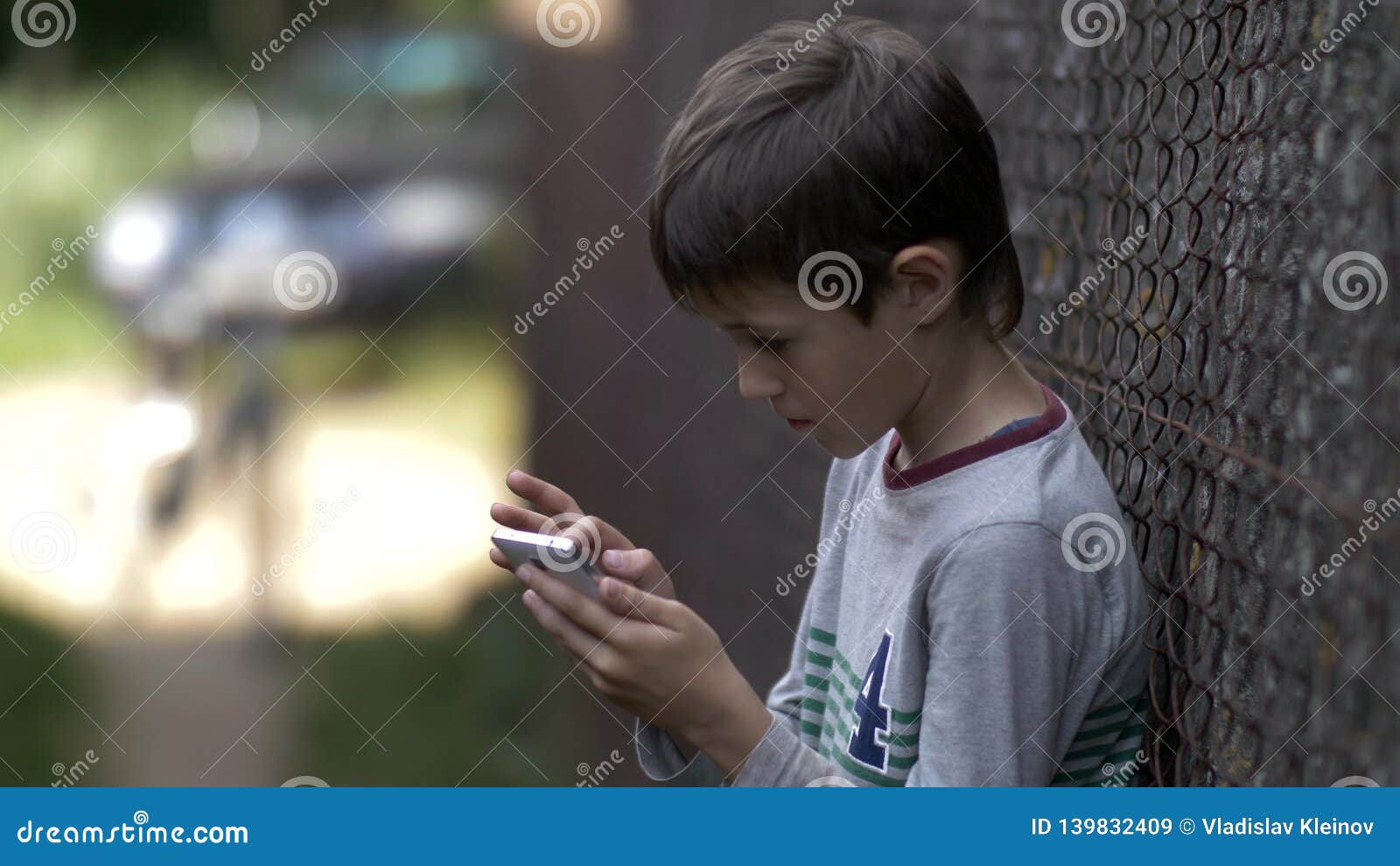 Serious Boy is Using the Phone in the Countryside Stock Image - Image ...