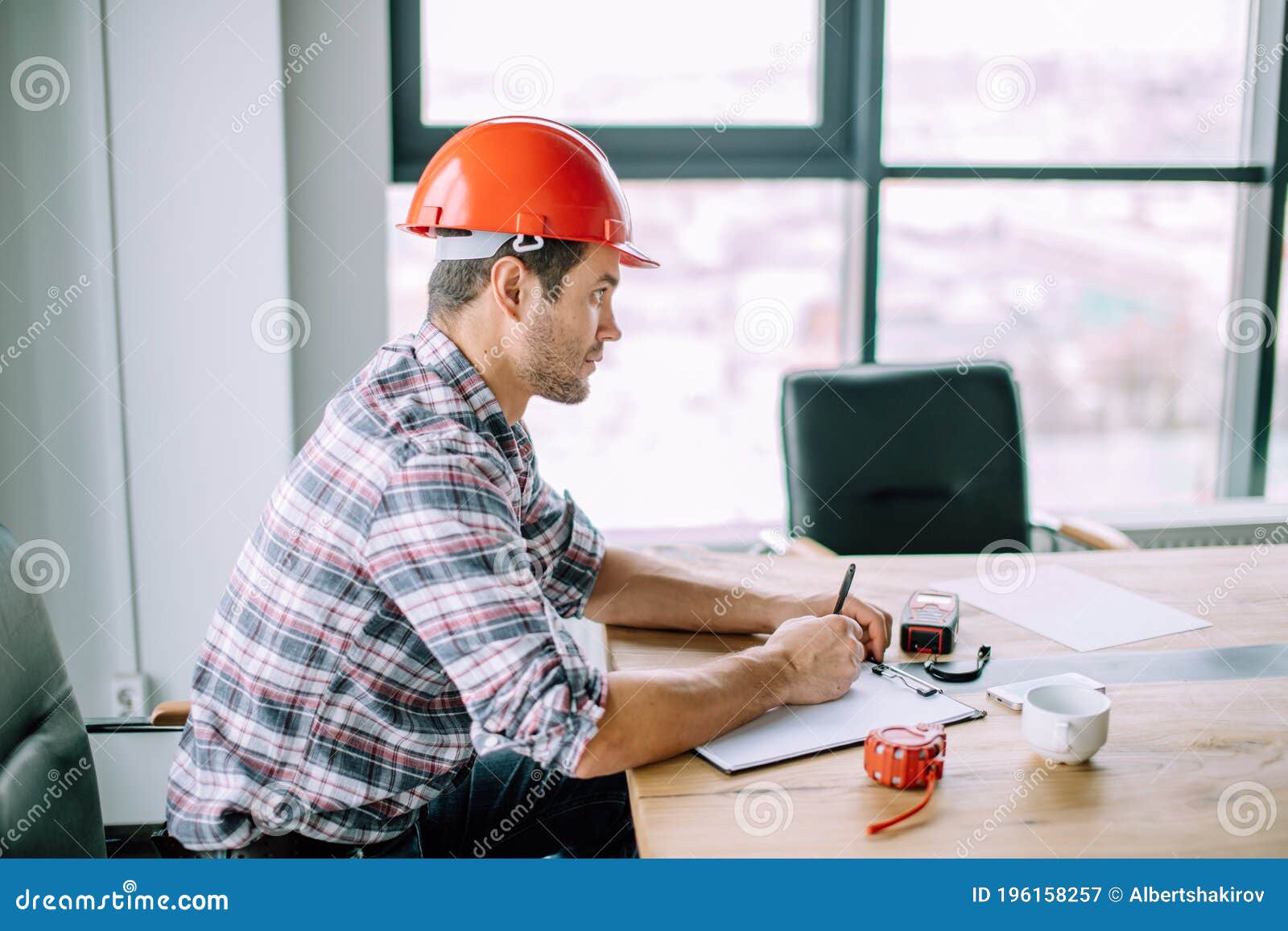 Serious Builder is Writing the Plan of Work in the Notepad Stock Image ...